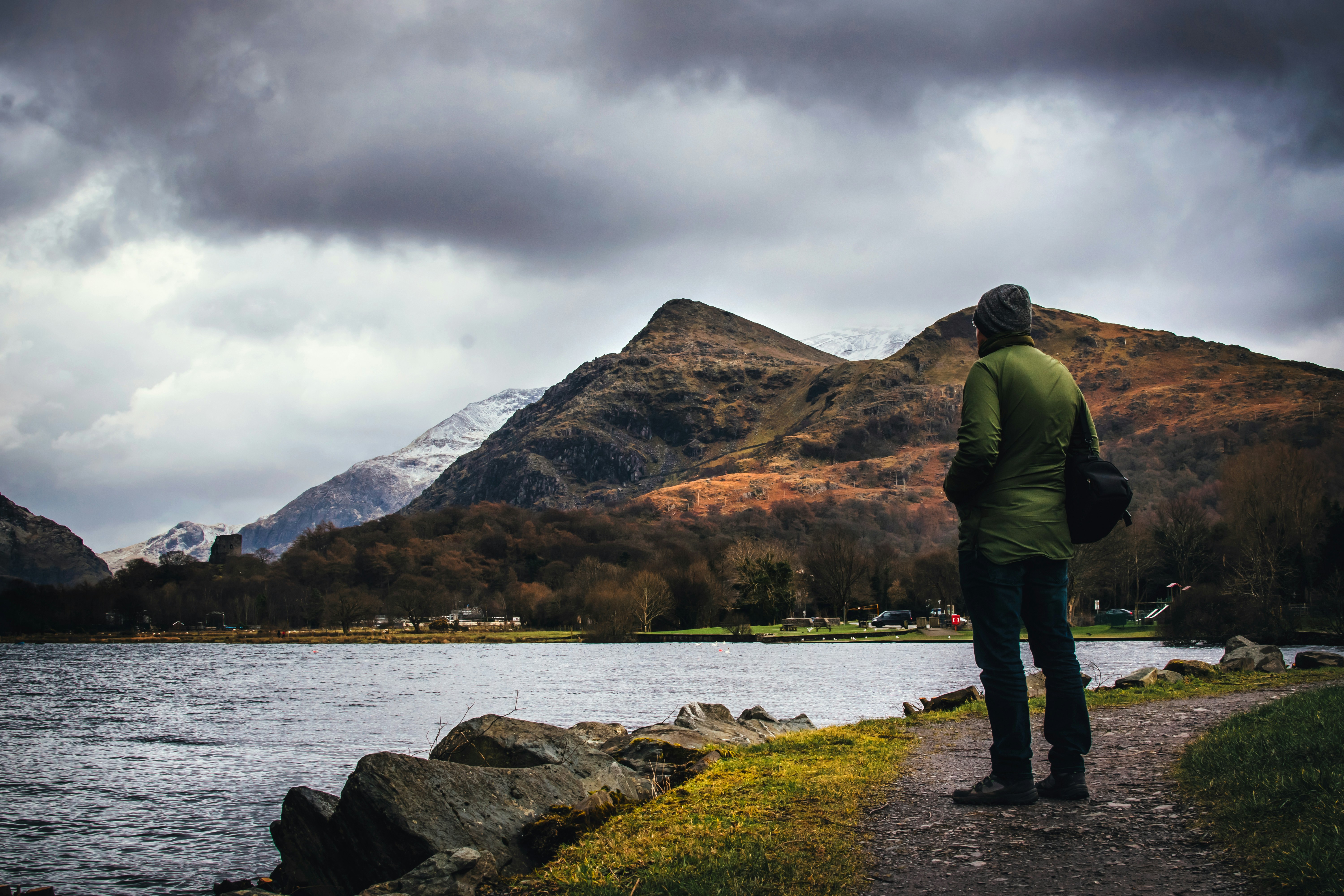 Man standing on ground facing body of w ater photo – Free Llanberis ...