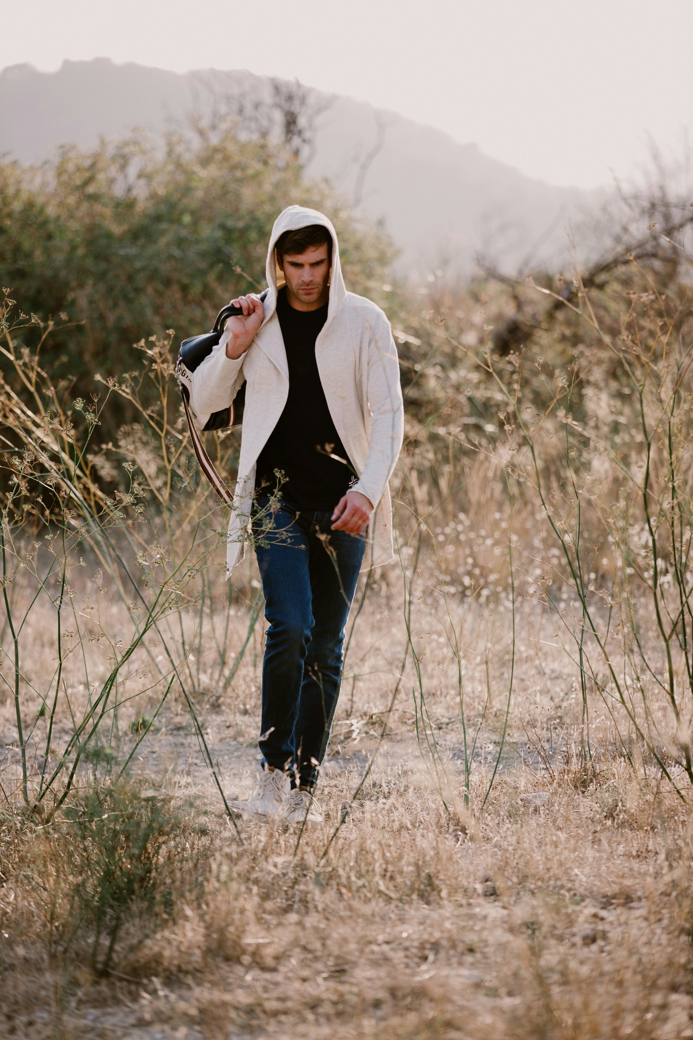 Golden Hour Stride: A Photographer Carries the Light Through Dry Grass