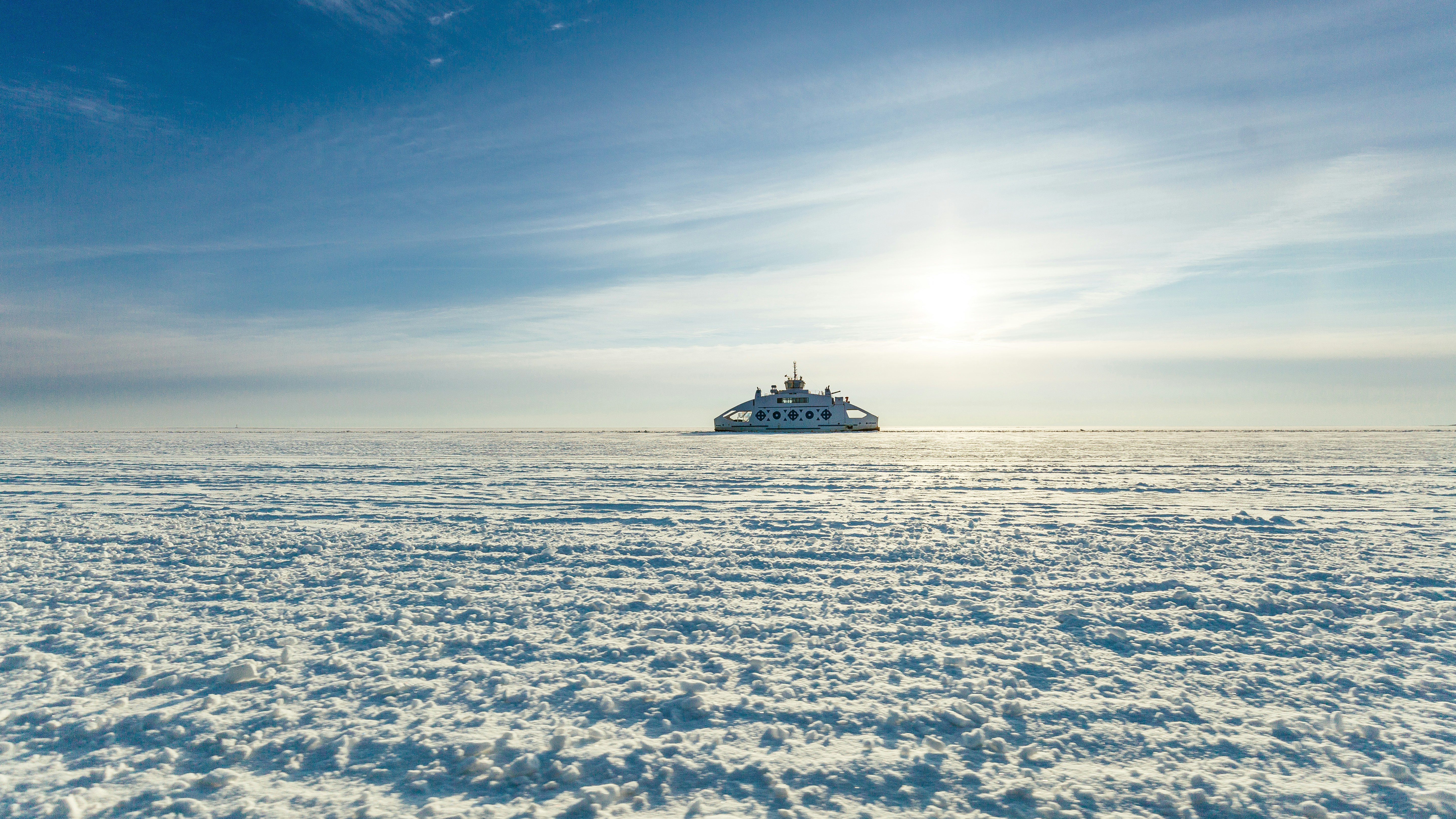 Solitary Vessel on a Frozen Sea at the Sunlit Horizon