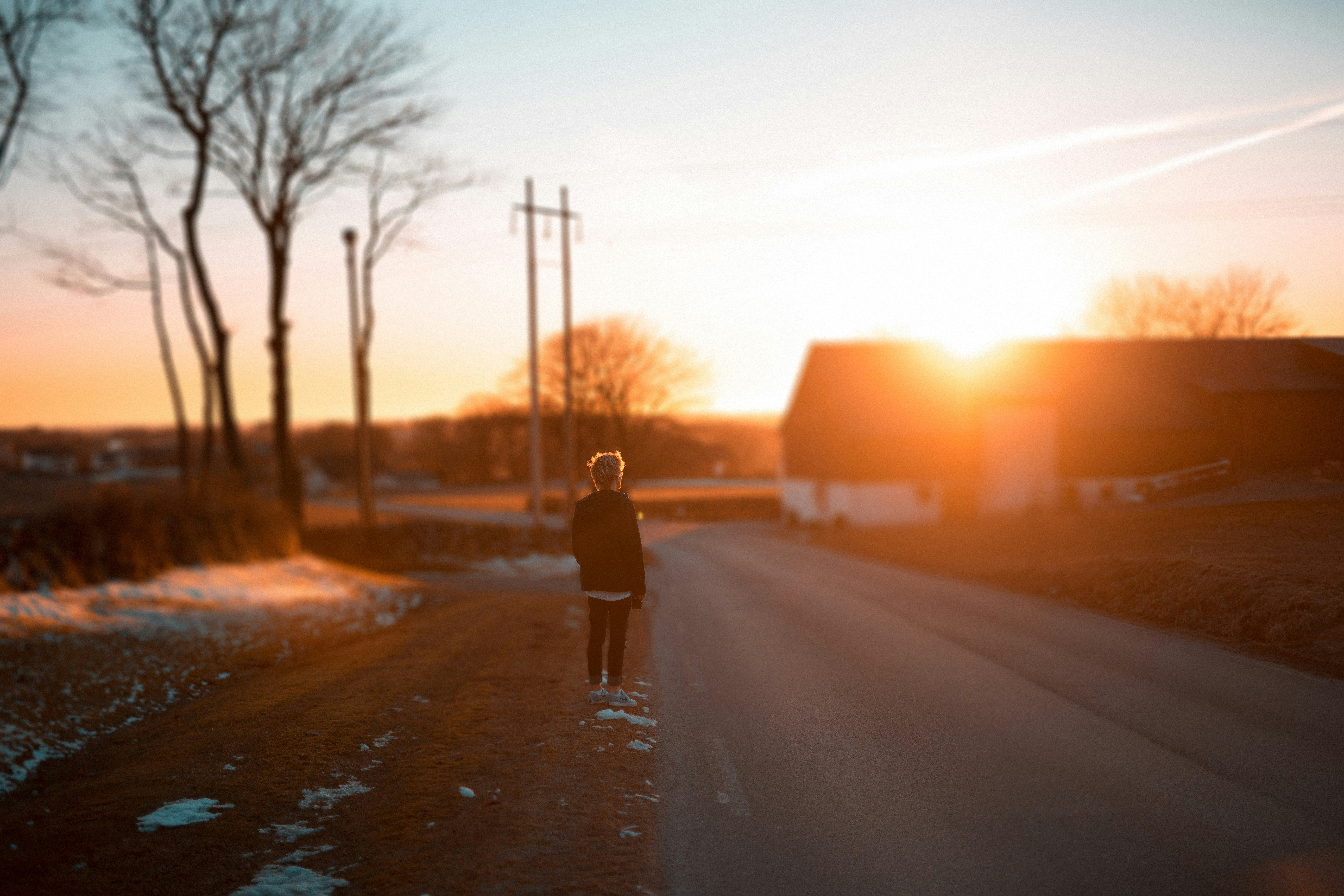 Crimson Quiet: A Lone Figure on the Rural Sunset Road