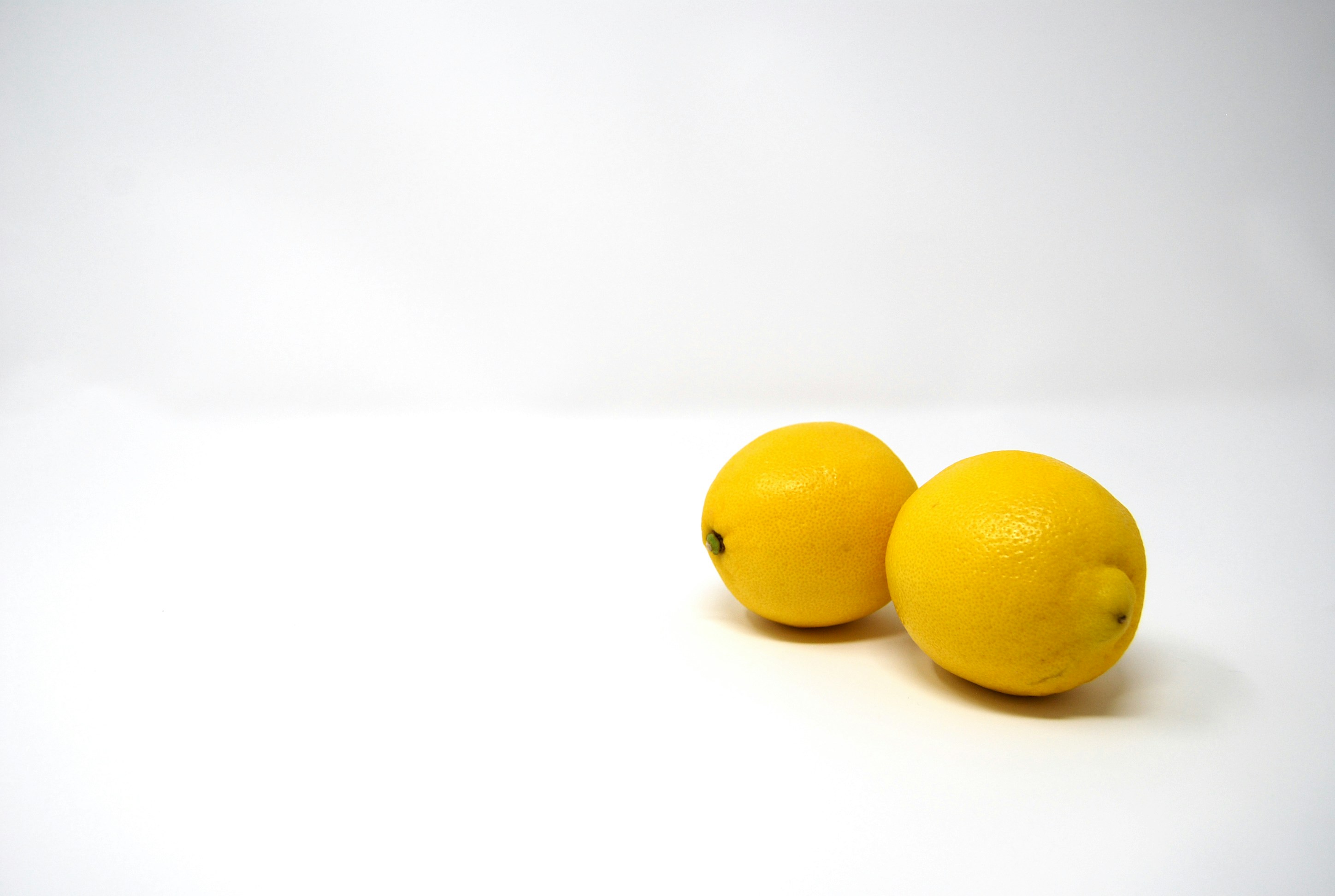 I always find myself needing simple, clean photos of objects on a plain background, and there are never enough to find. So I got a big white box (large enough for two cats to stand up comfortably, ask me how I know) and will be taking pictures of various things in it. | two yellow lemons