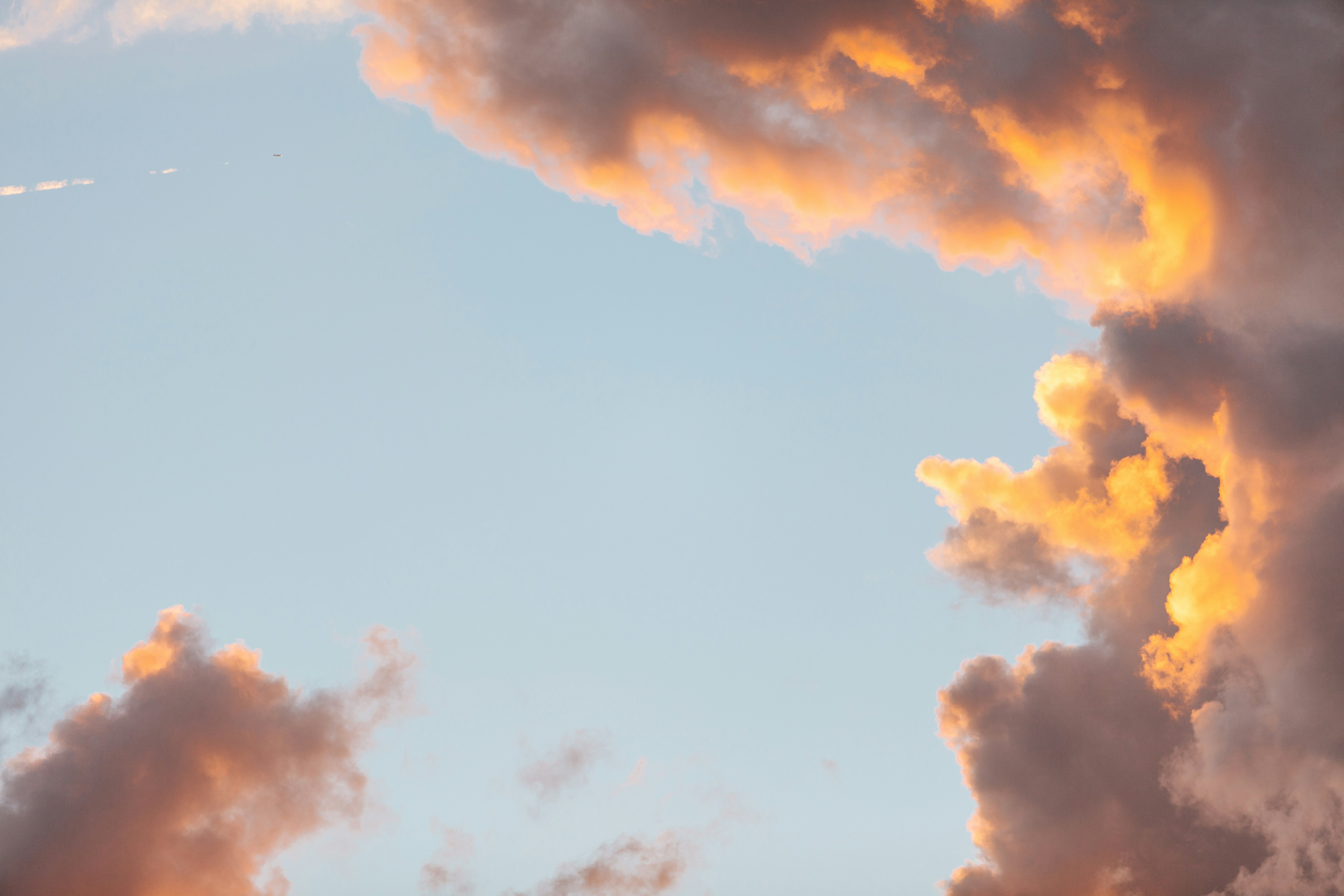 Golden-hued clouds framing a serene sky at dusk, highlighting the transition from day to night.