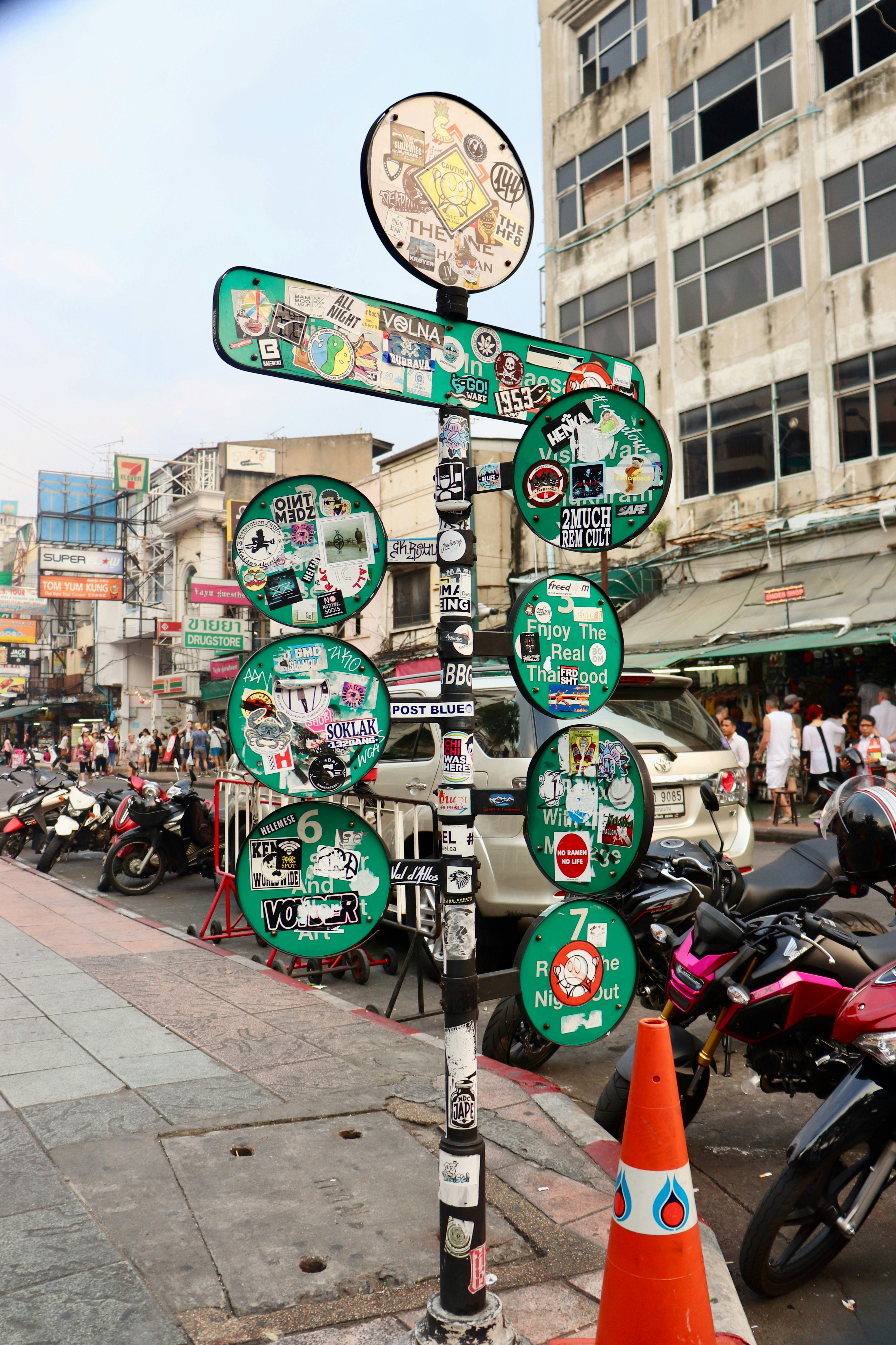 Stickered Sentinel: A Signpost Jumble Along a Busy Street