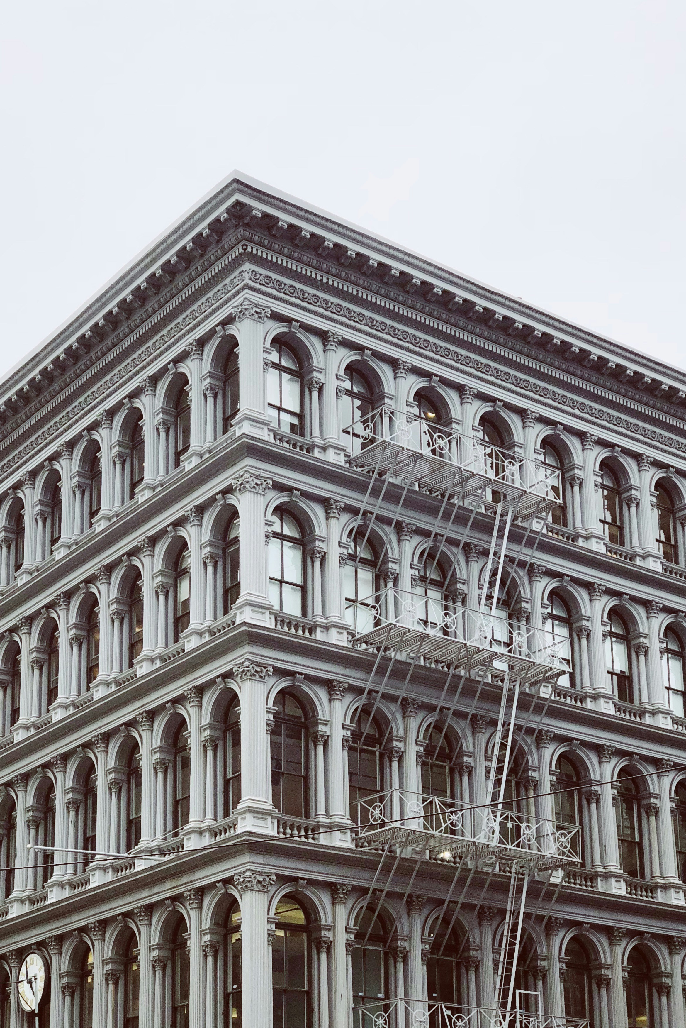 Tiered Facade Silence: The Fire Escape weaves through Neoclassical Arches