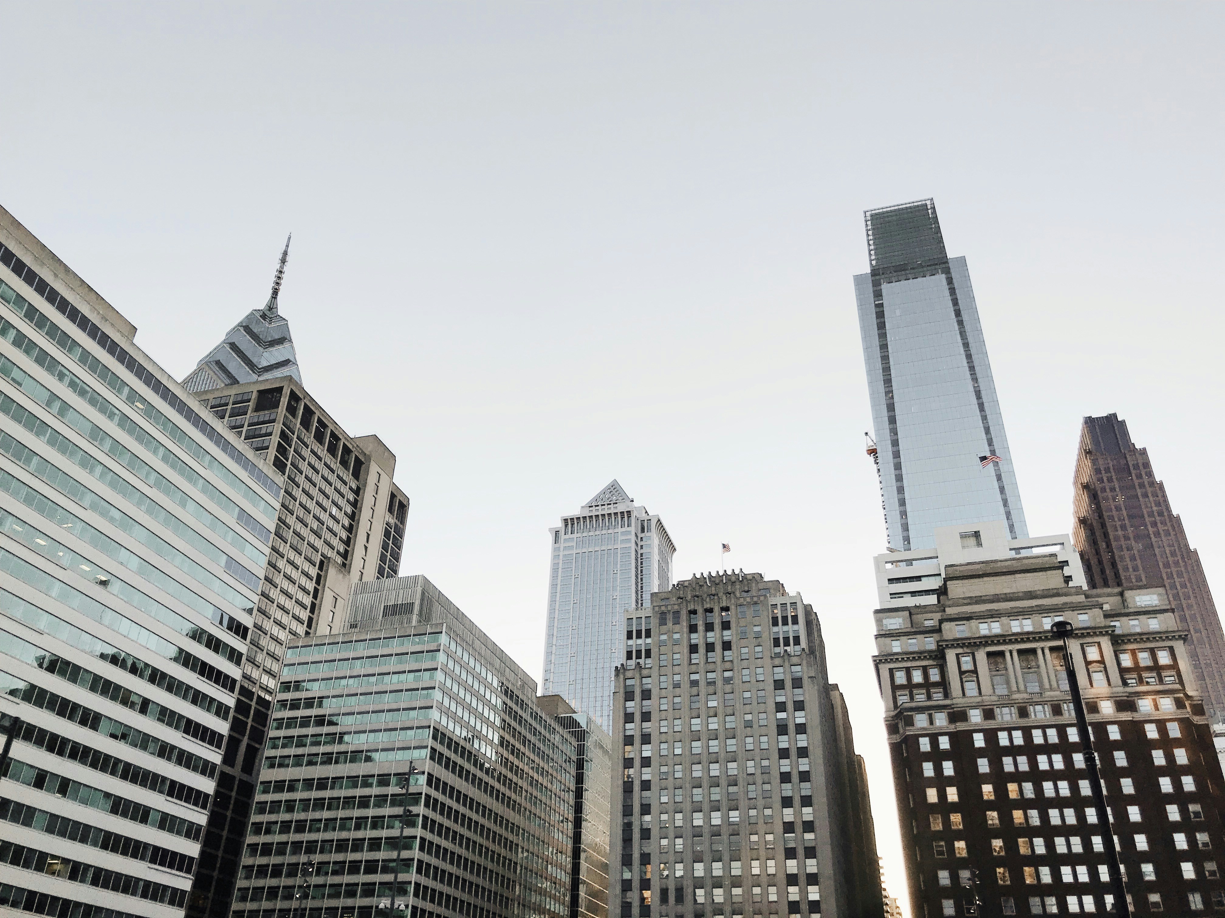 Skyscrapers rise against a clear sky, showcasing diverse architectural styles.