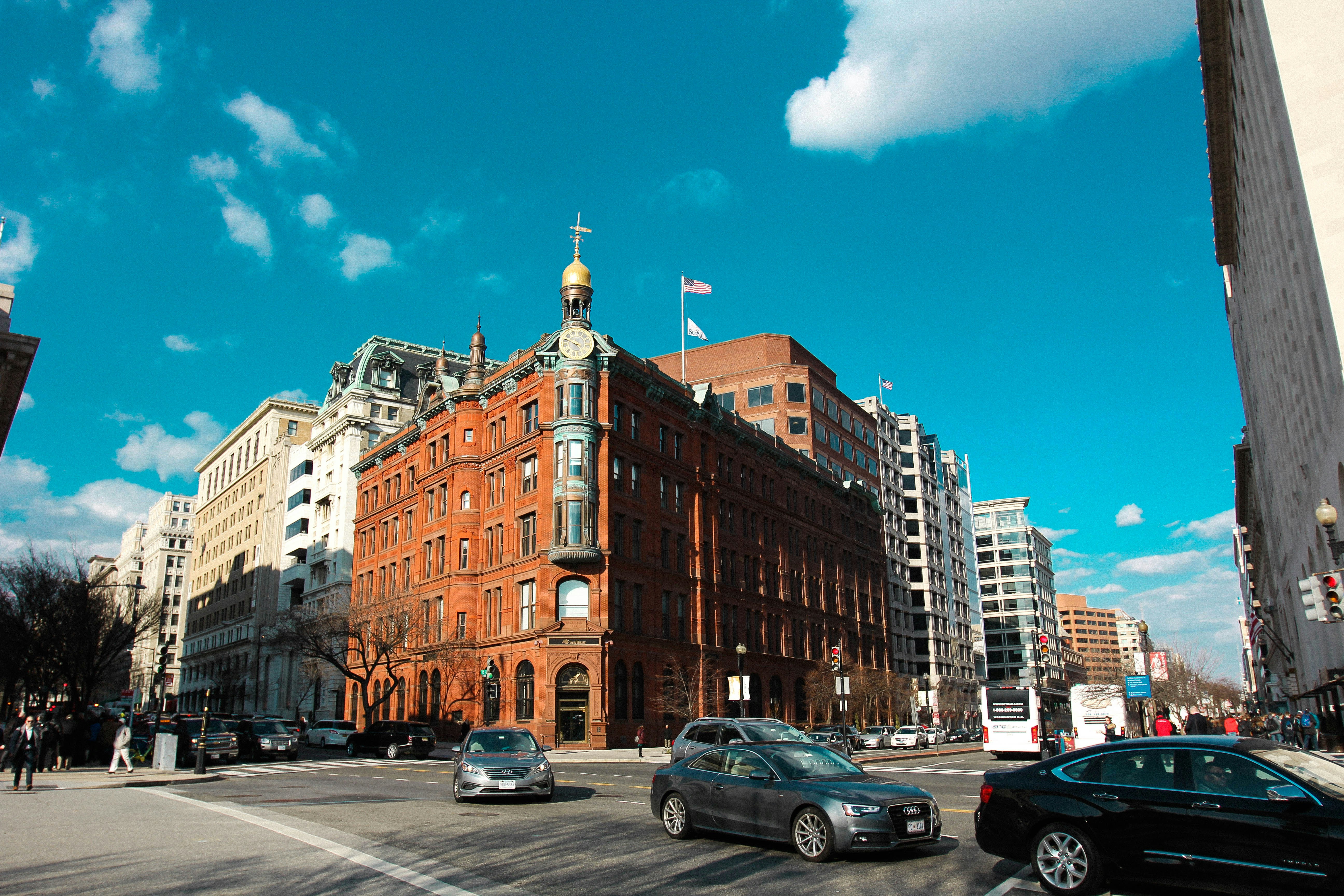 Brown high-rise building near the road with cars photo – Free Sky Image ...