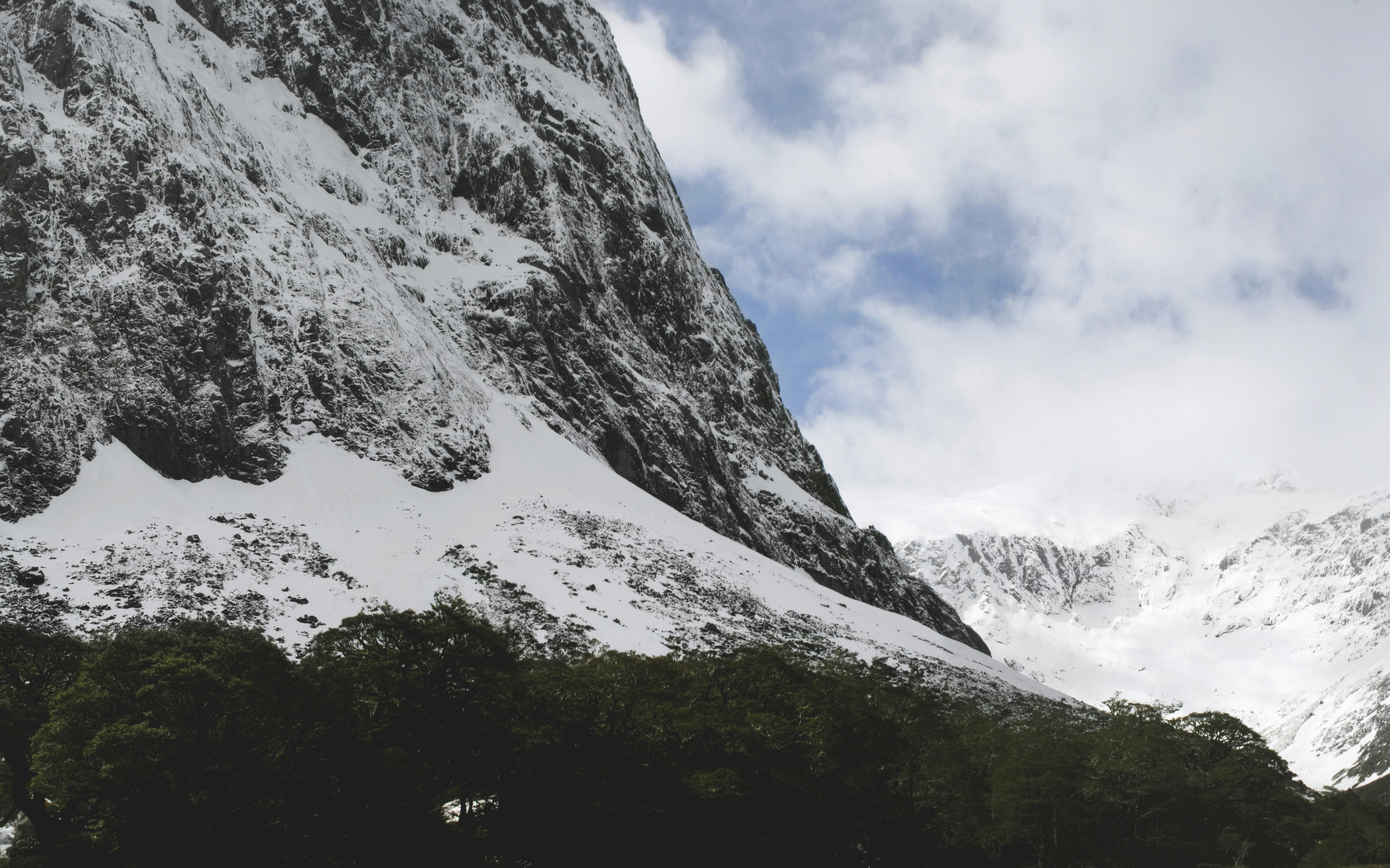 Snow-Crowned Cliff Over a Quiet Pine Forest