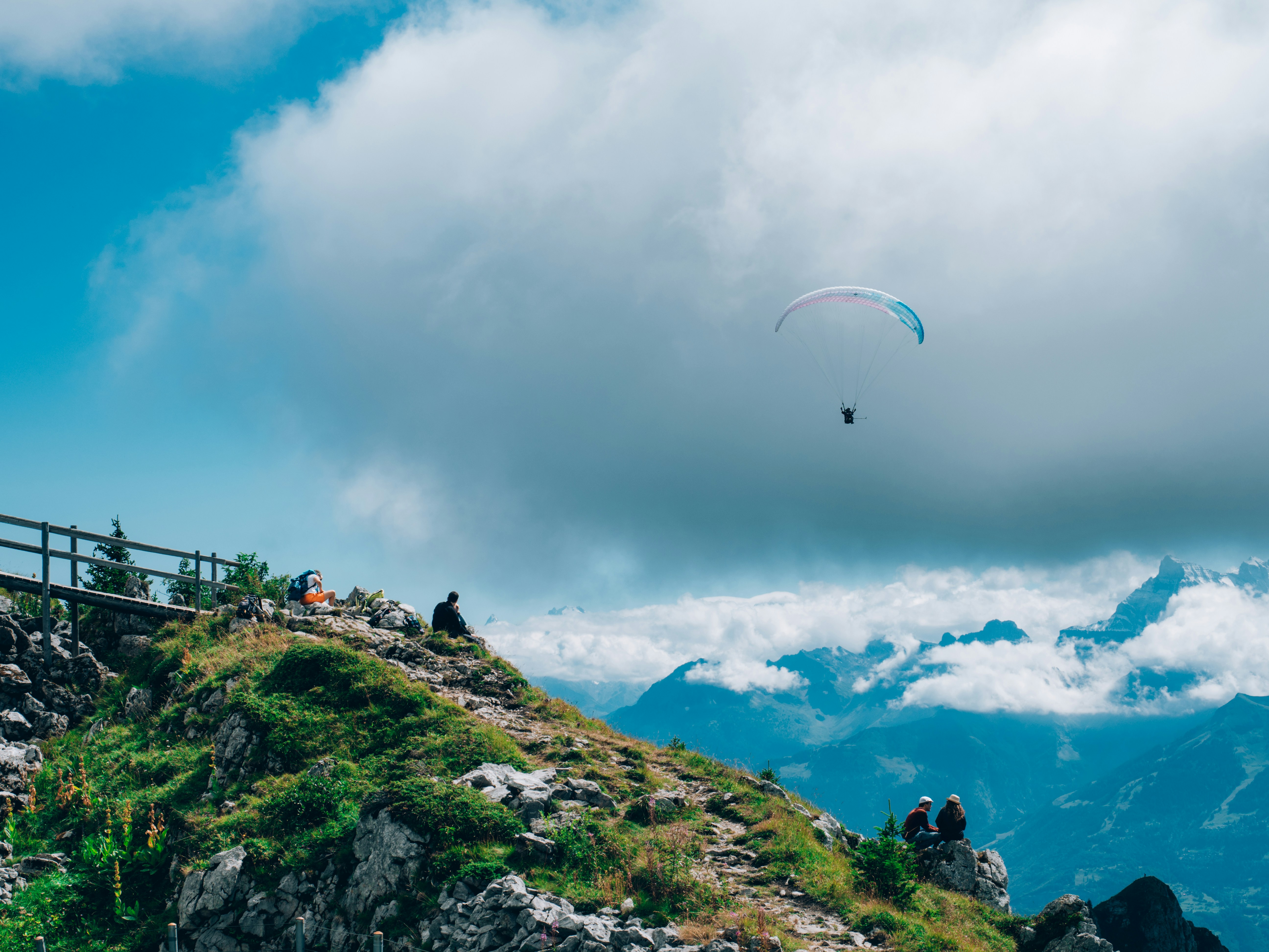 Arc Above the Alpine Ridge: Paraglider Skimming the Sky