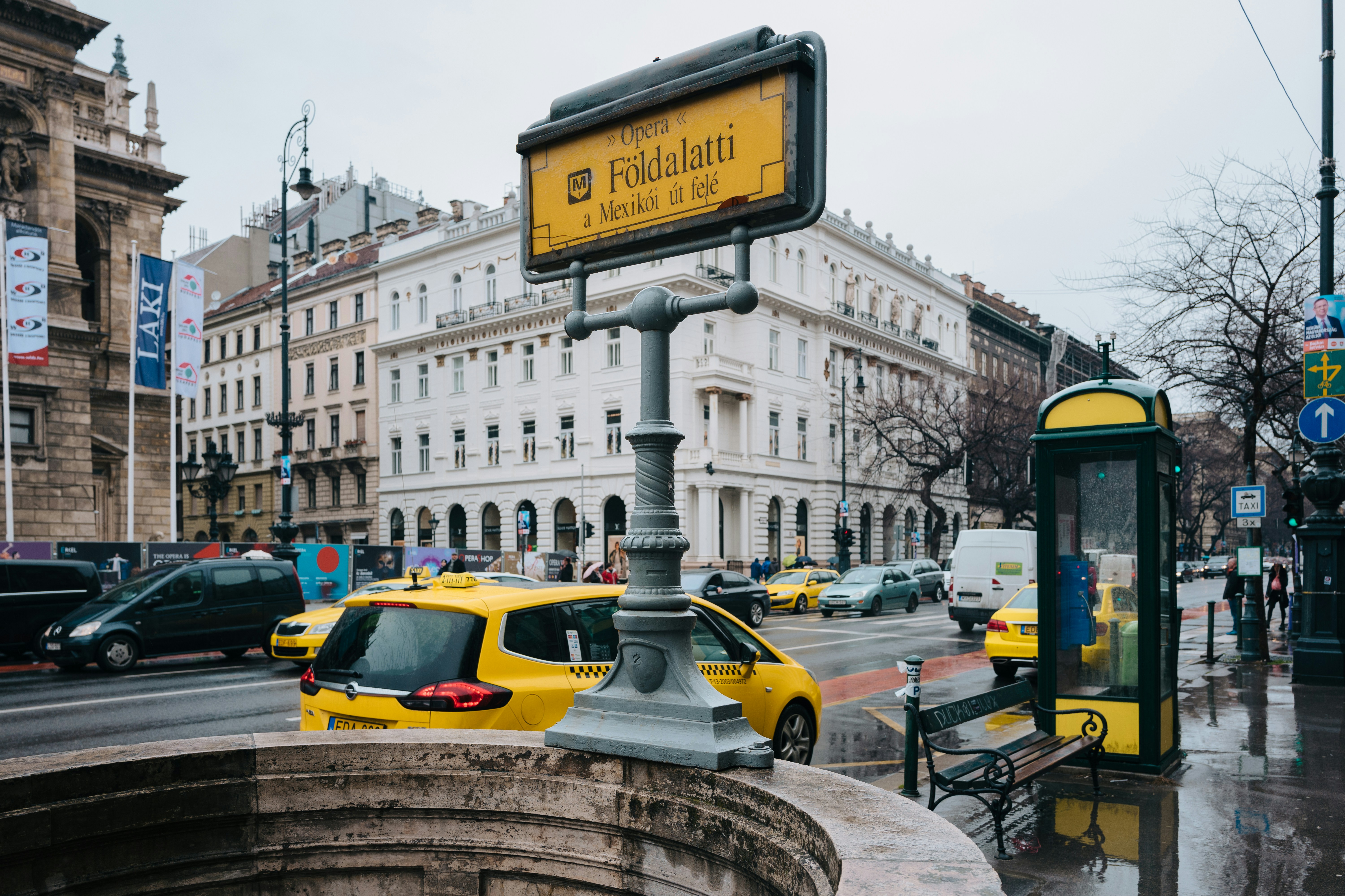 Underground Sign and Yellow Taxis: A European Street Scene in Rain