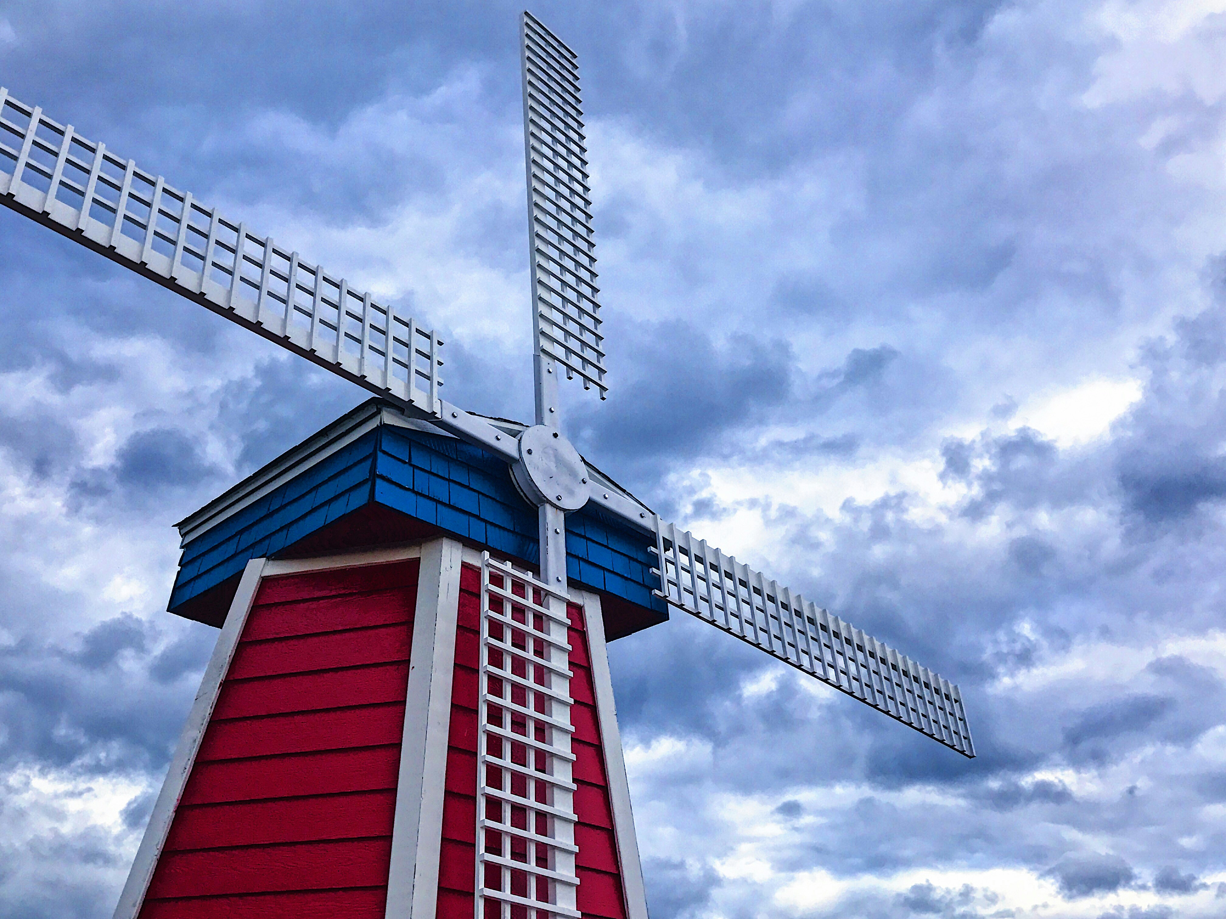 The weather was about to take a turn for the worse. The sky was darking and the clouds gathering together when I took this shot. I love how the windmill stands strong against the weather that is to come. And oh how I love the color contrast! | white and red barn house with wind mill