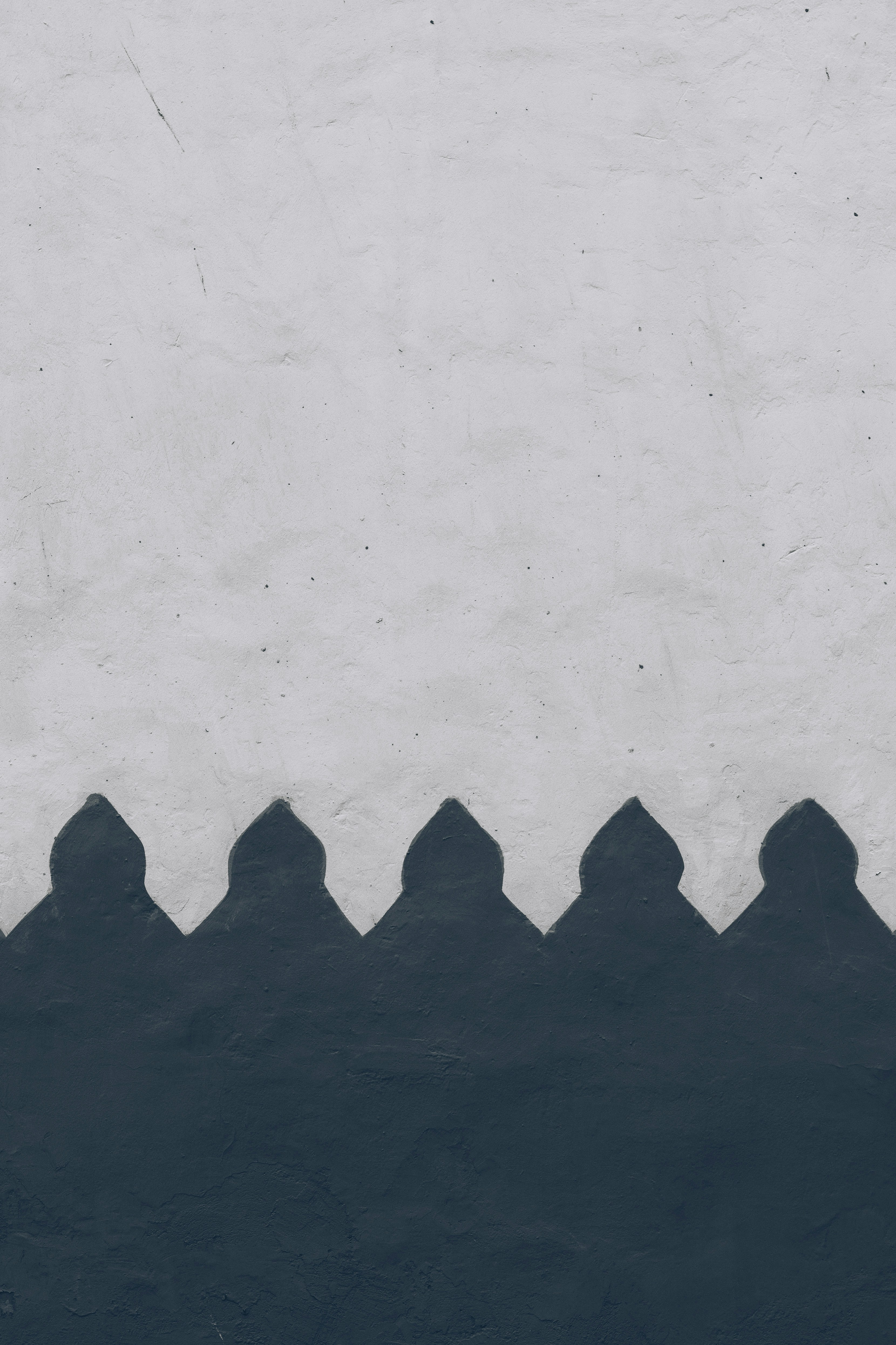 Intricate shadow patterns cast by a decorative wall, contrasting with a smooth white surface above.