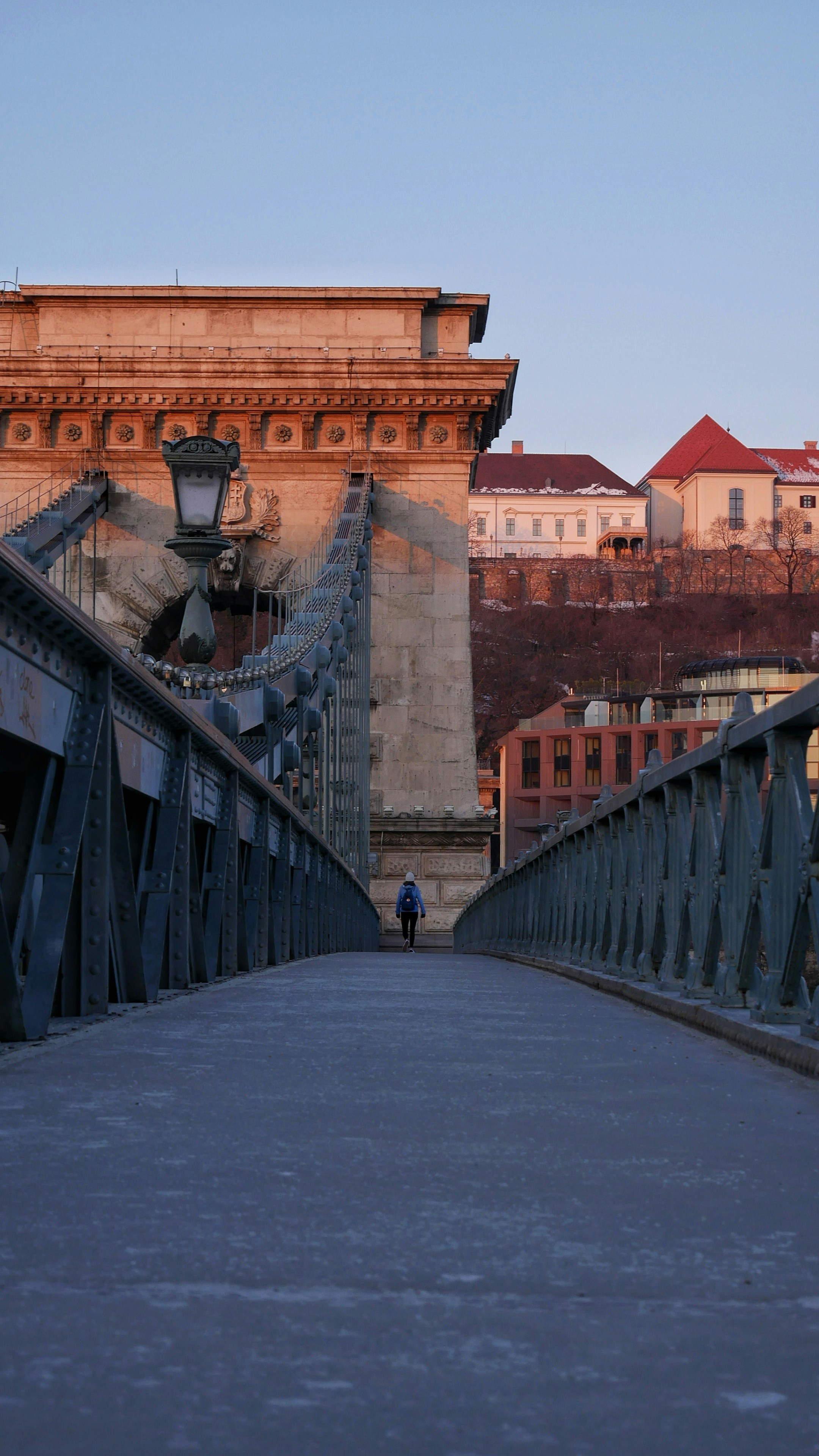  lone traveler on a stone bridge toward a grand city facade