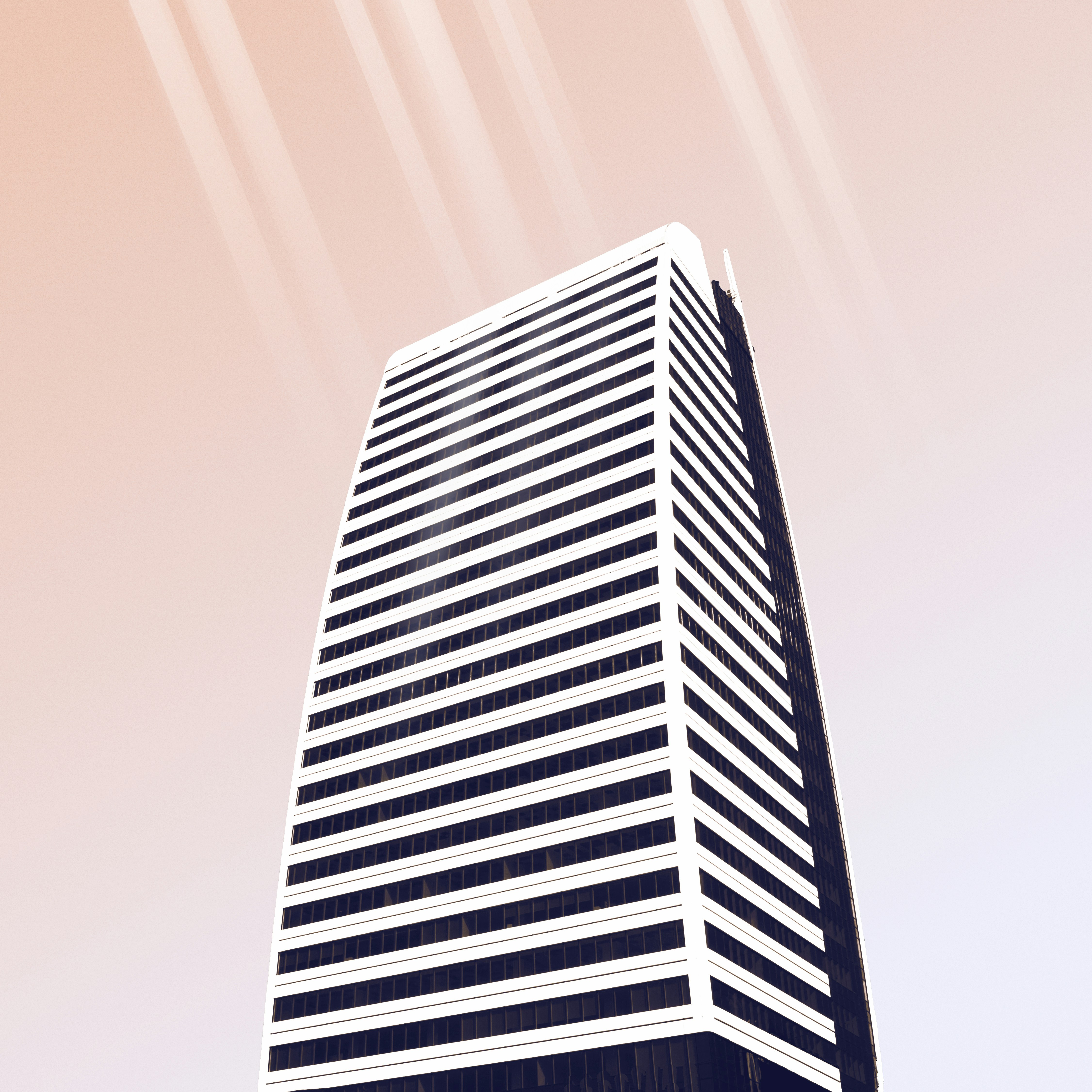 A sleek skyscraper with a striking striped facade reaching towards a pastel sky, showcasing contemporary design elements.