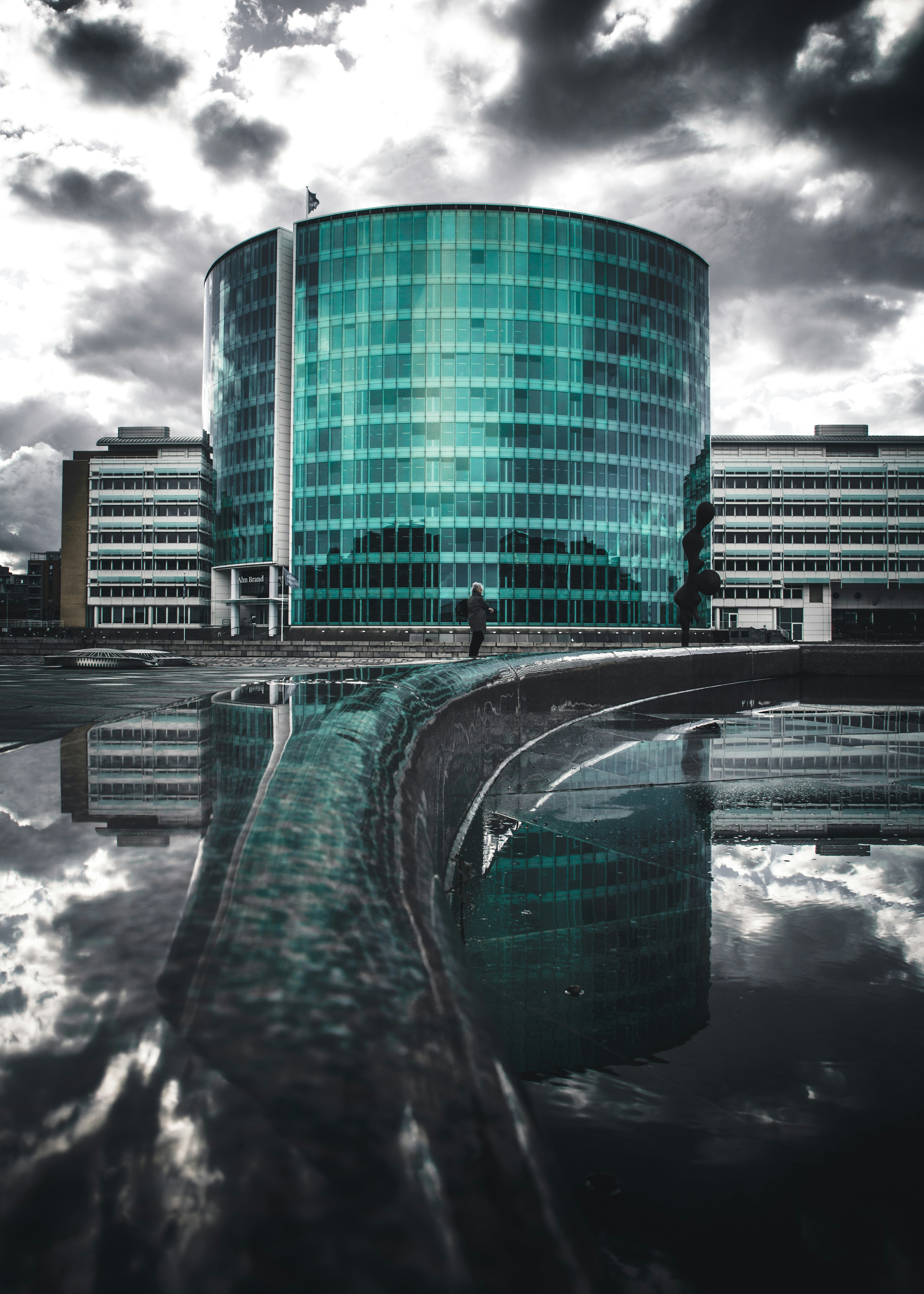 Turquoise Cylinder: Reflections Across a Wet Plaza