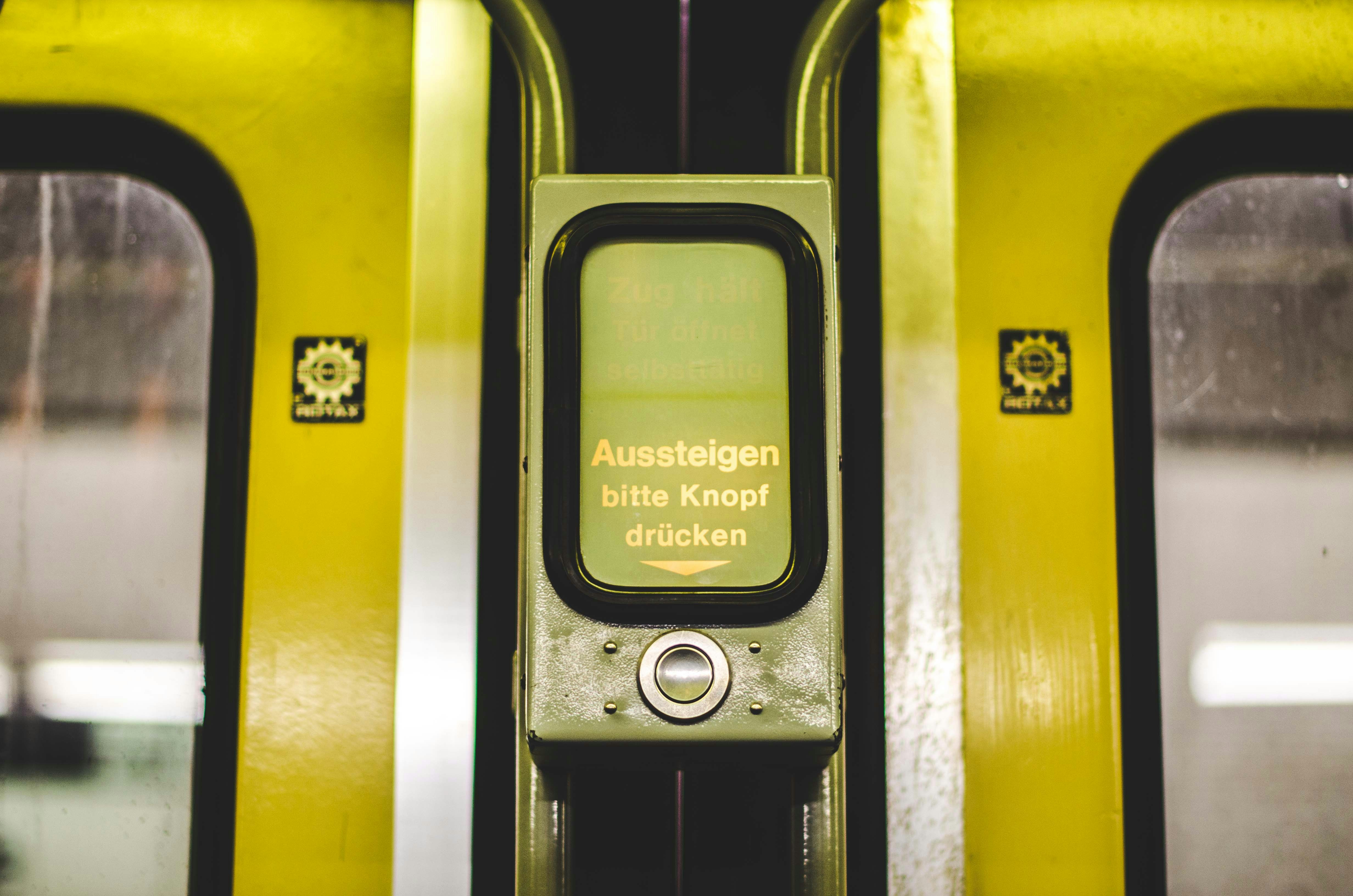 Quiet Command at the Yellow Door: Close-Up of the Transit Button