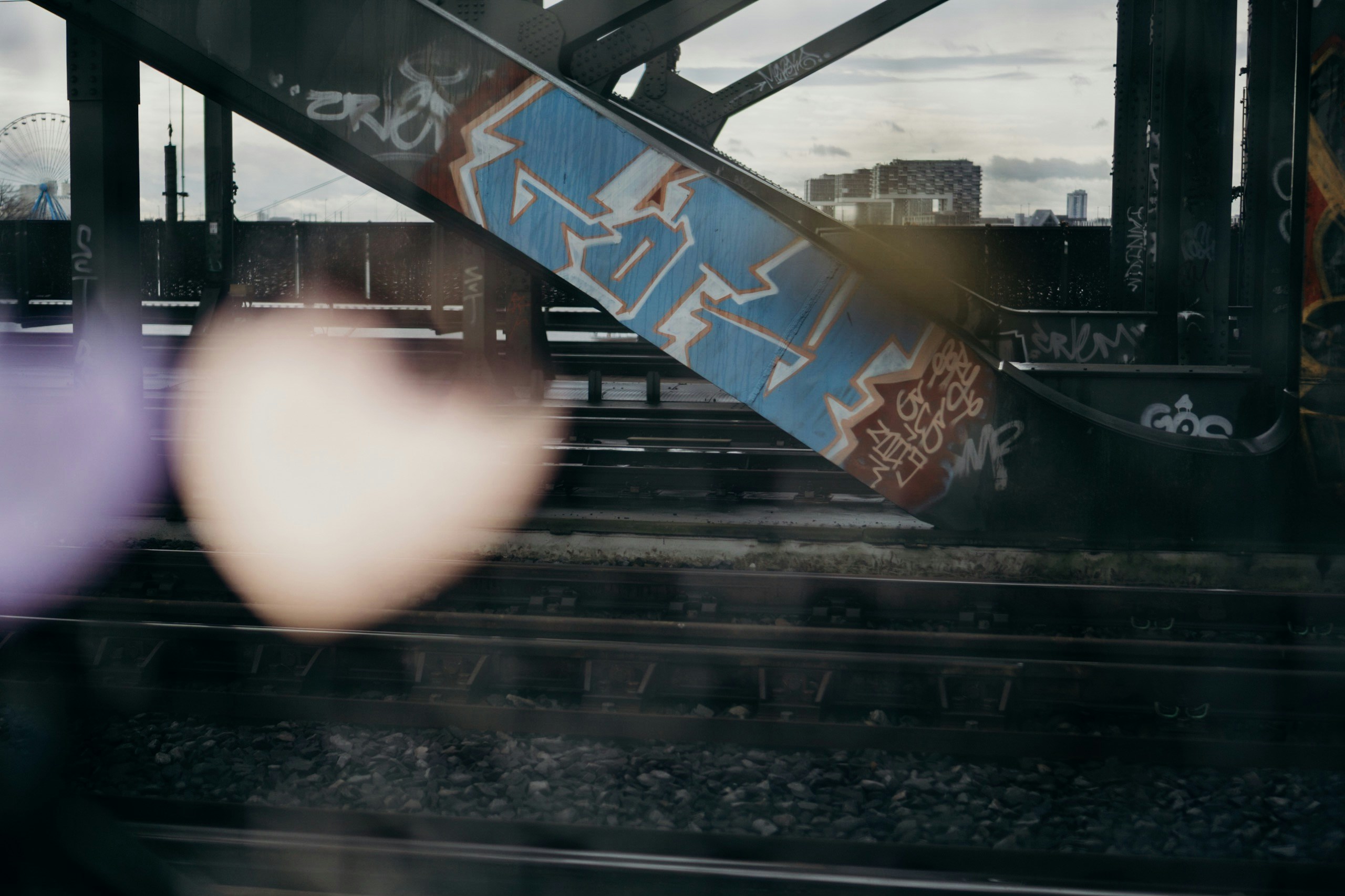 Diagonal Graffiti Banner Slicing Through an Industrial Rail Scene
