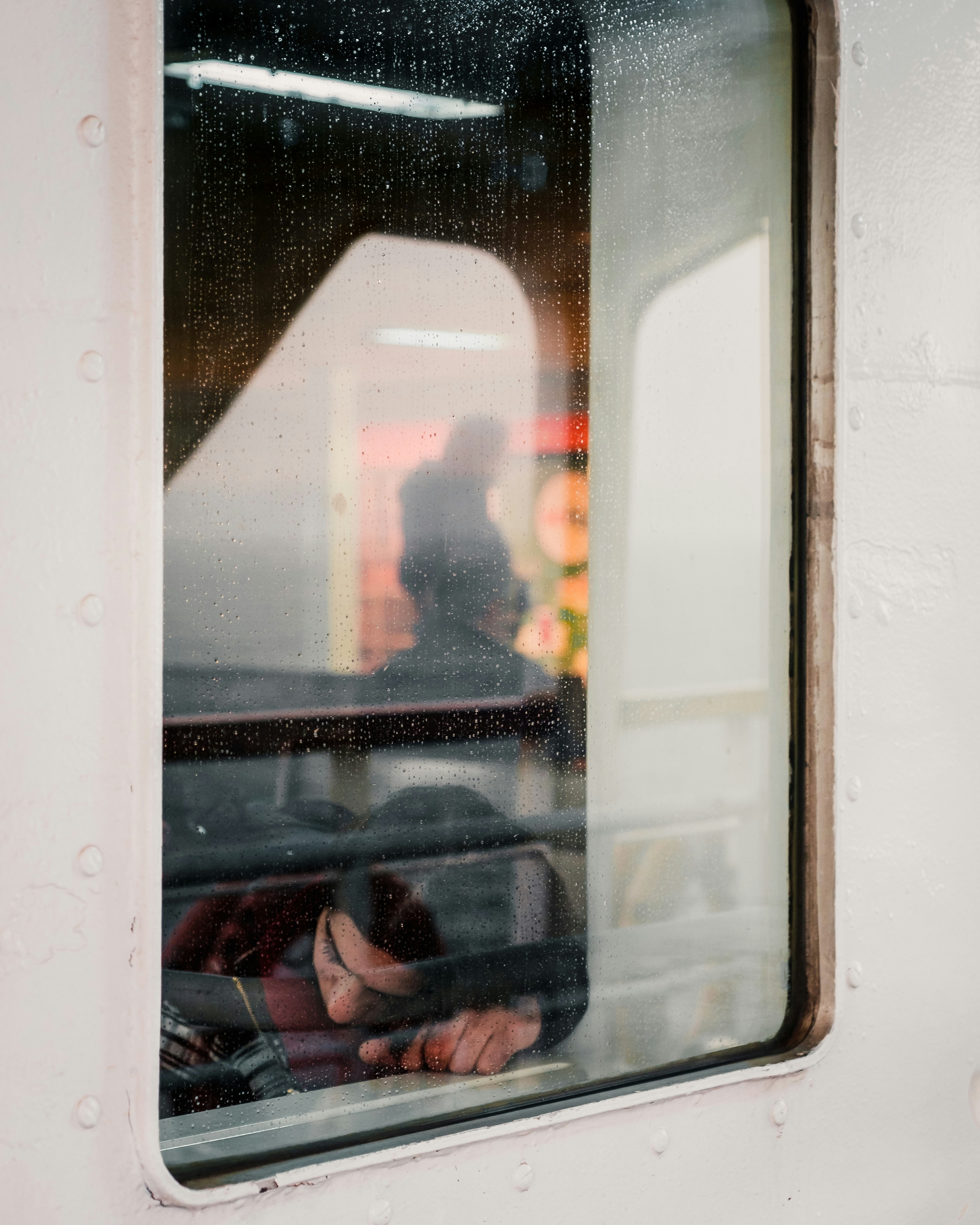 Rain-Streaked Glass, a Sleeper in the Quiet Train Car