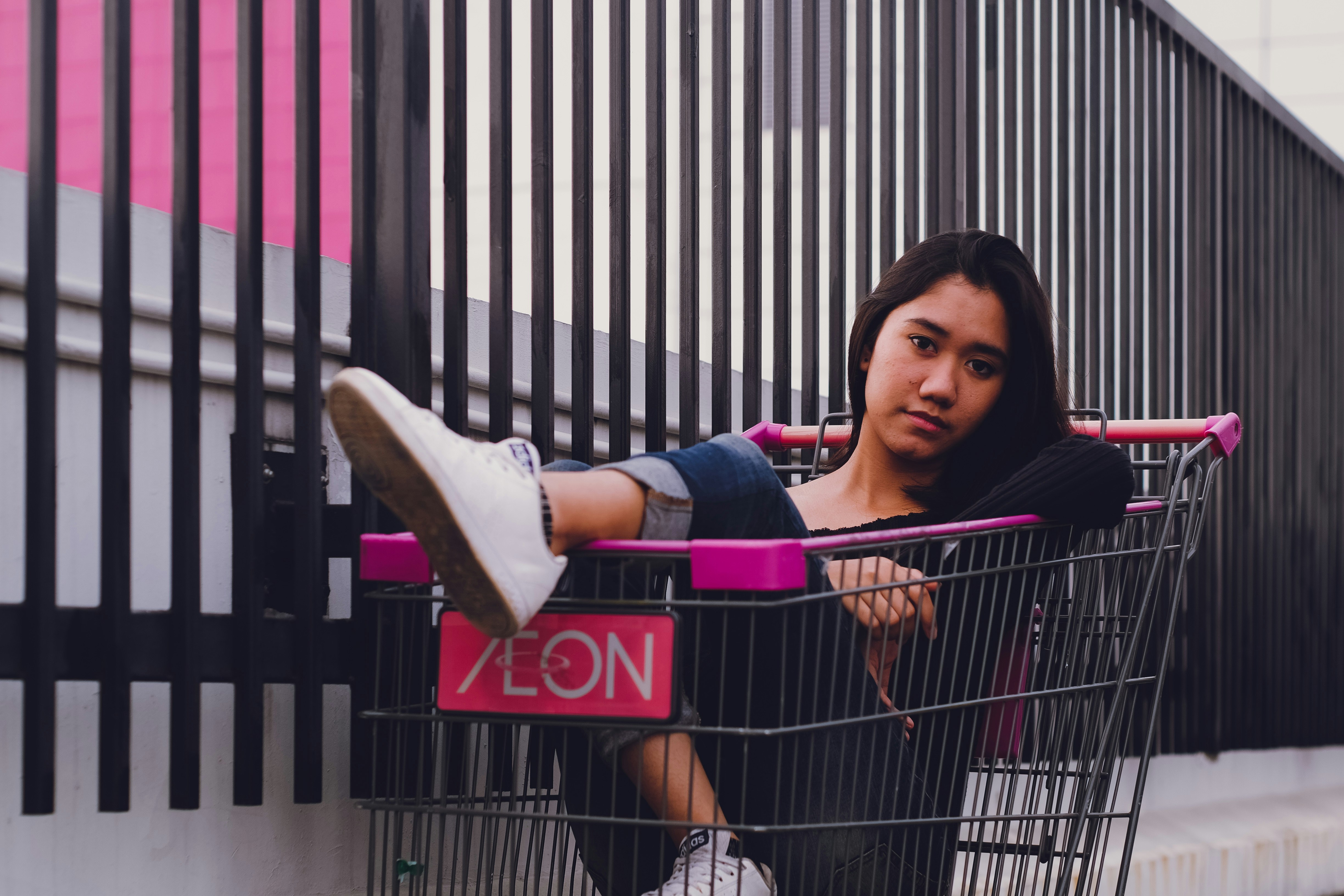 Pink Handles, Quiet Gaze: A Portrait in a City Shopping Cart