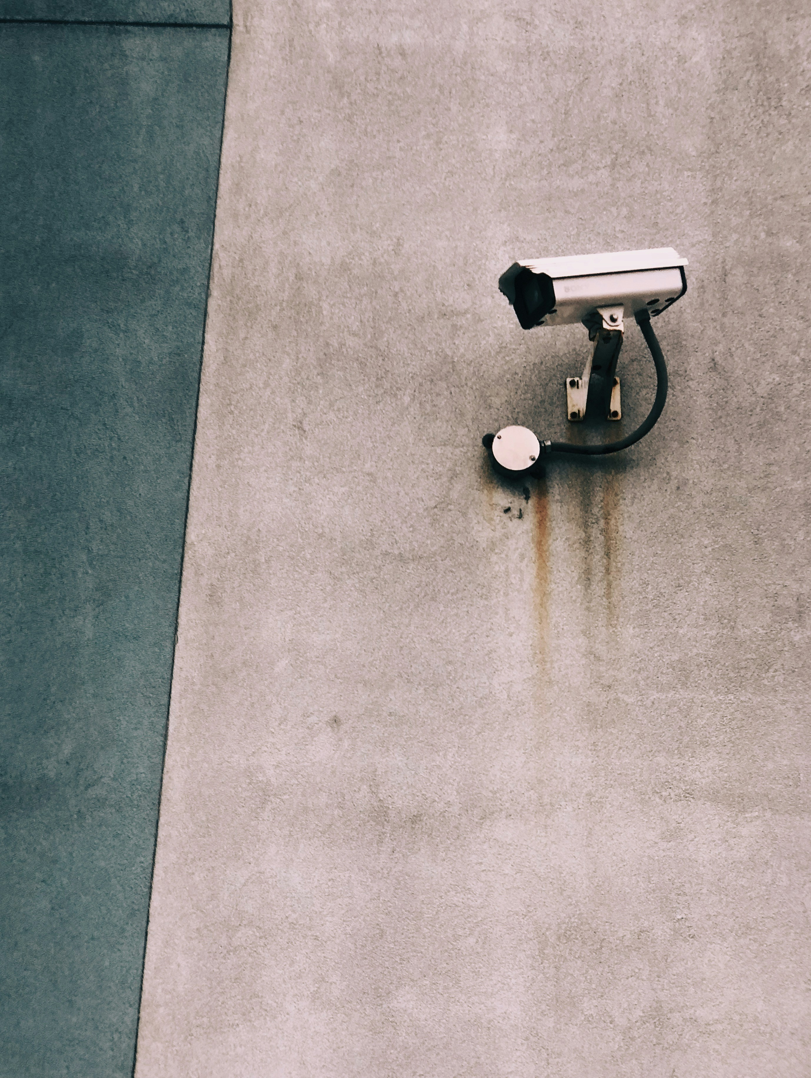 Sentinel on Weathered Concrete: A Minimal Wall-Mounted Surveillance Moment