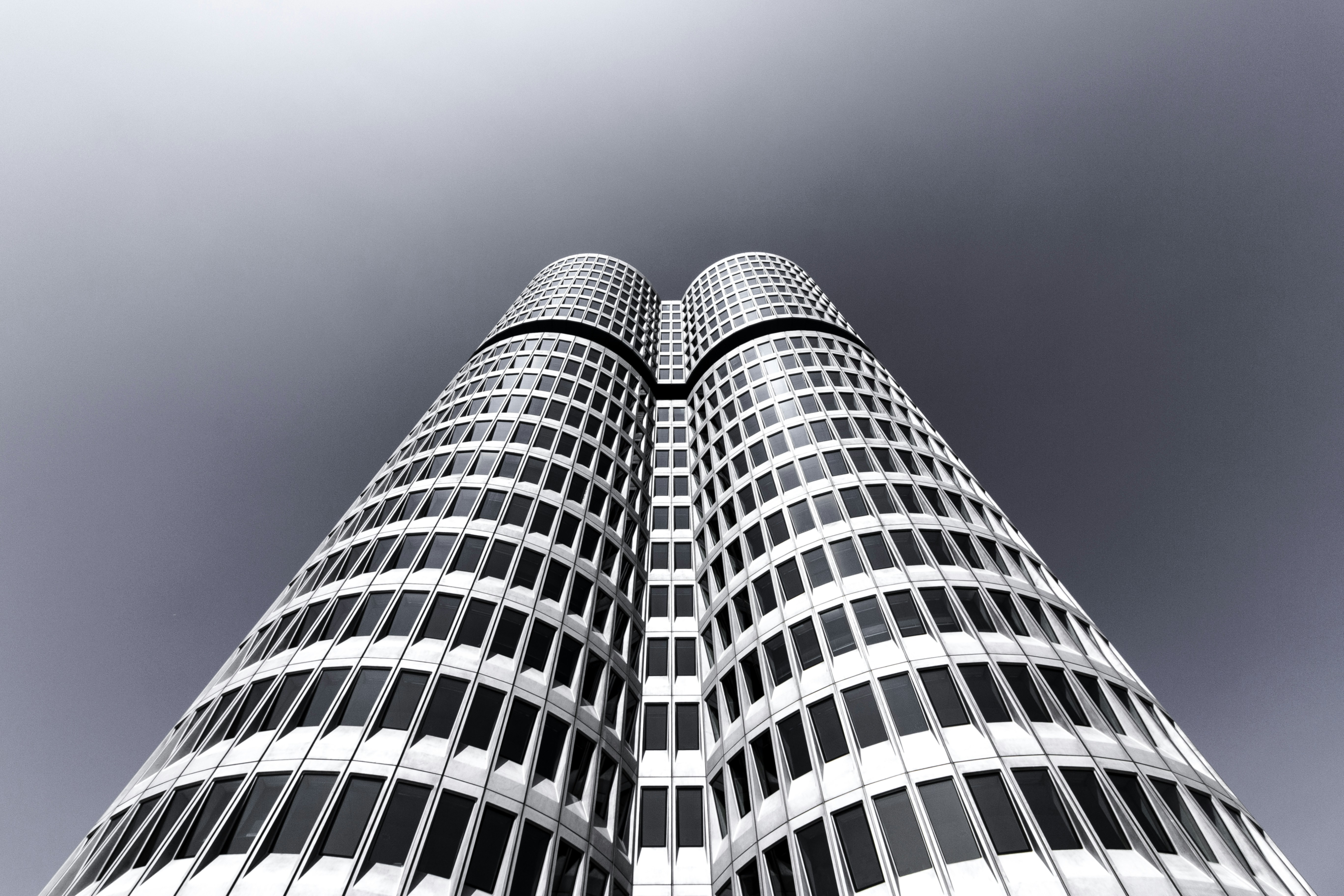 Symmetrical twin towers rise into a cloudy sky, showcasing modern architectural design.