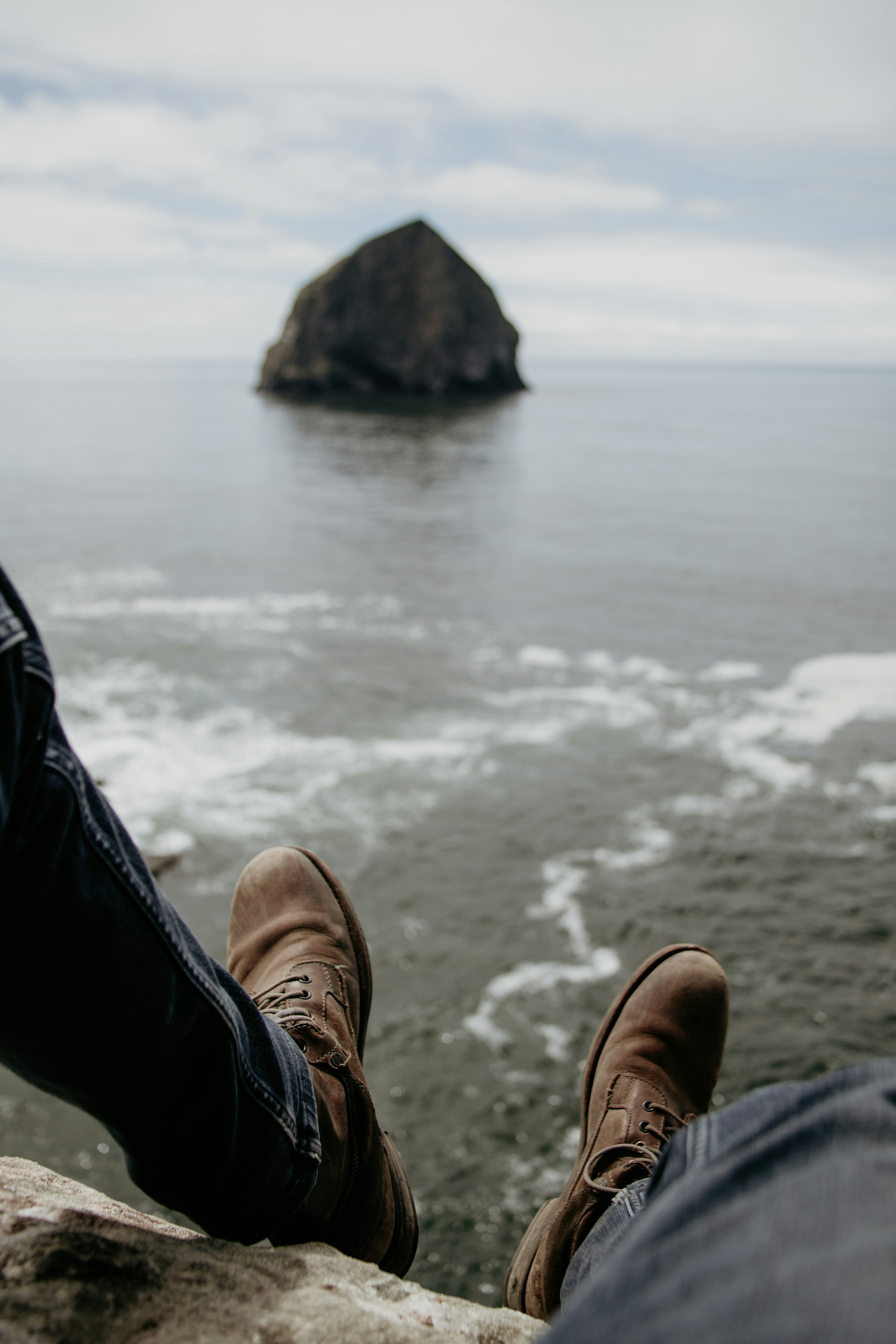 Person sitting on rock formation photo – Free Beach Image on Unsplash