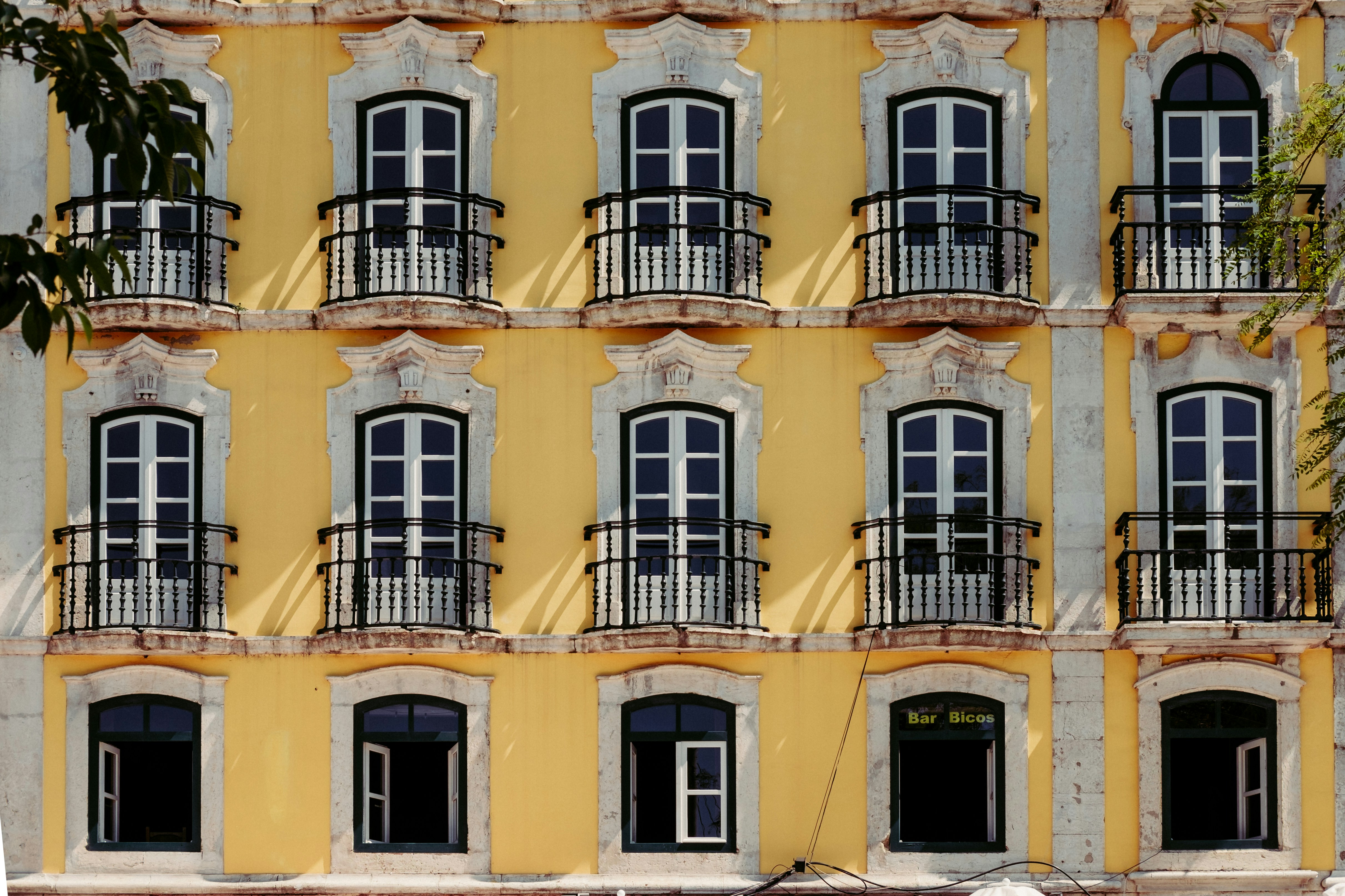 Yellow facade with ornate windows and balconies in Alfama, Lisbon.
