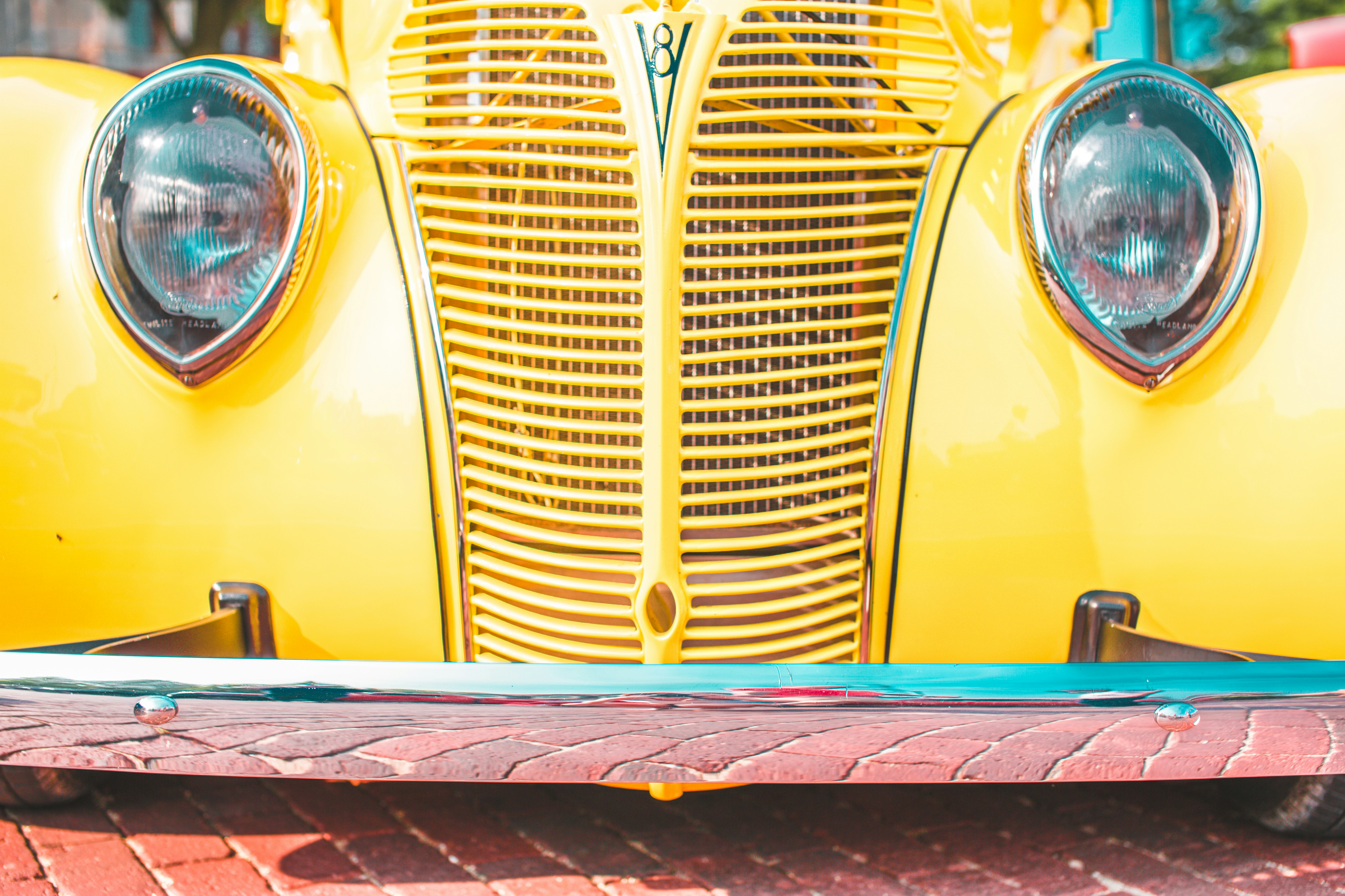 Centrepiece Glow: Close-Up on a Yellow Vintage Car's Grille