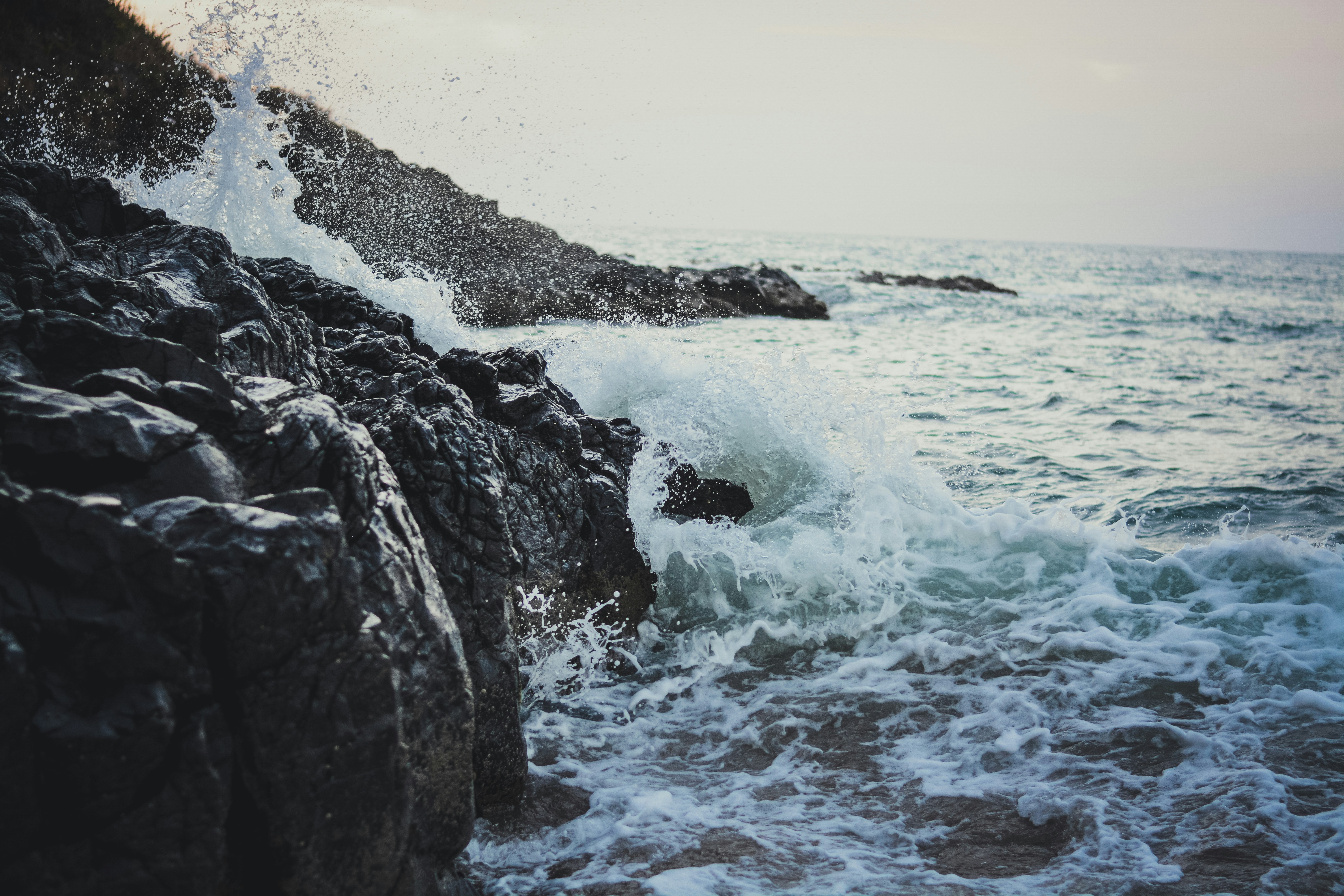 Waves crashing against rugged rocks at the shoreline, capturing the dynamic interaction between land and sea.
