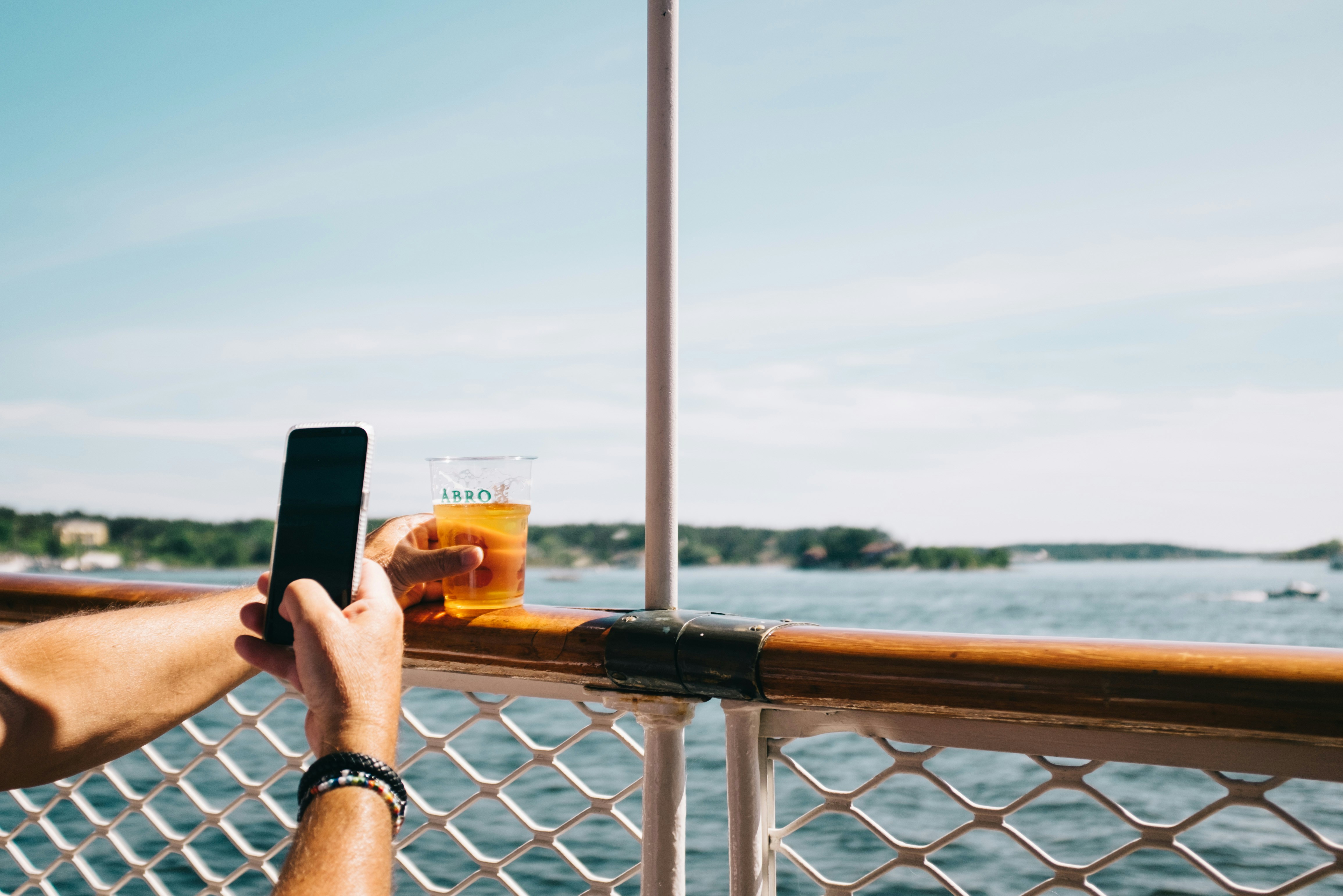 Glint of Citrus on the Rail: Smartphone Pause at Open Water