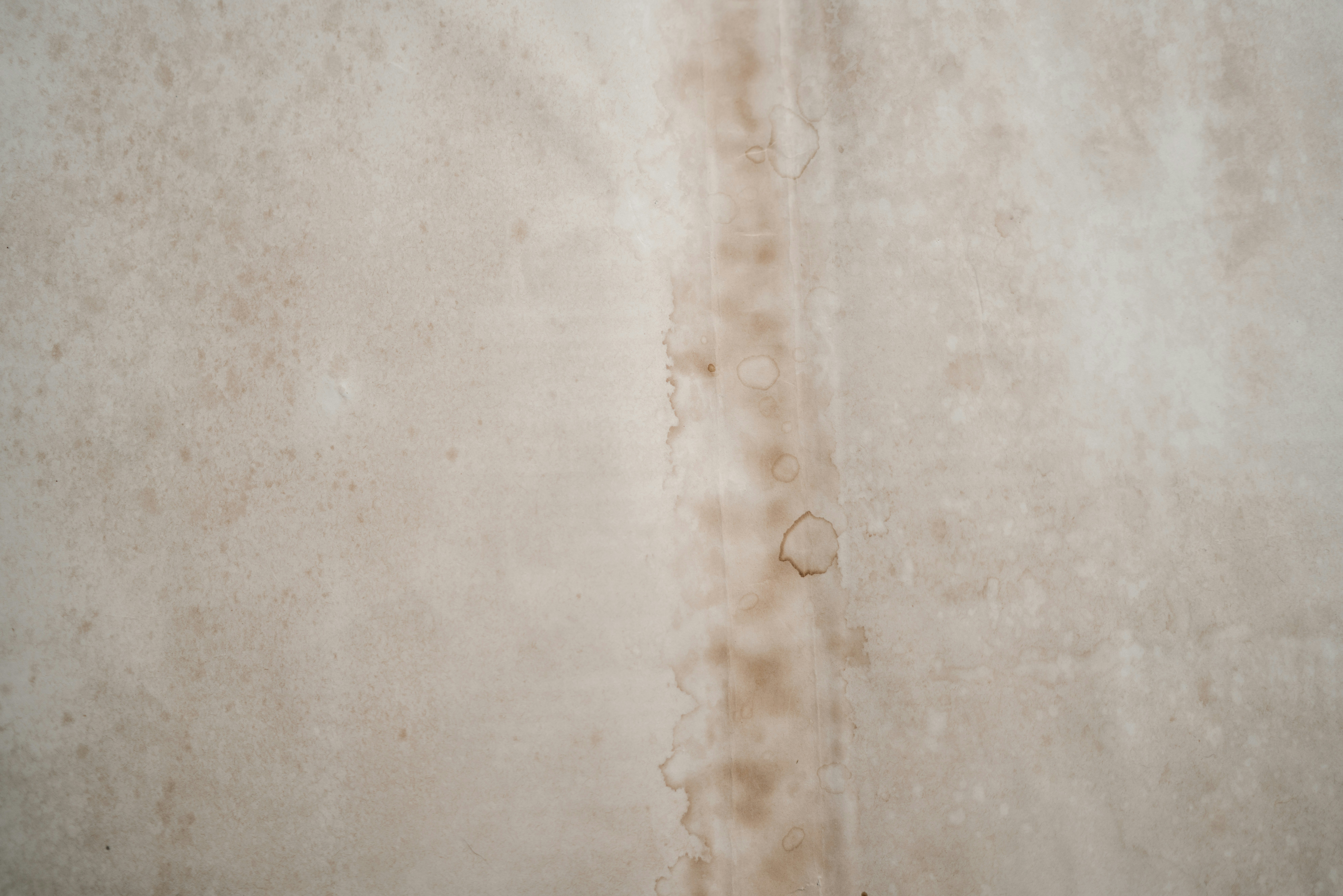 Textured surface revealing subtle stains and markings, suggesting a history of wear and age.
