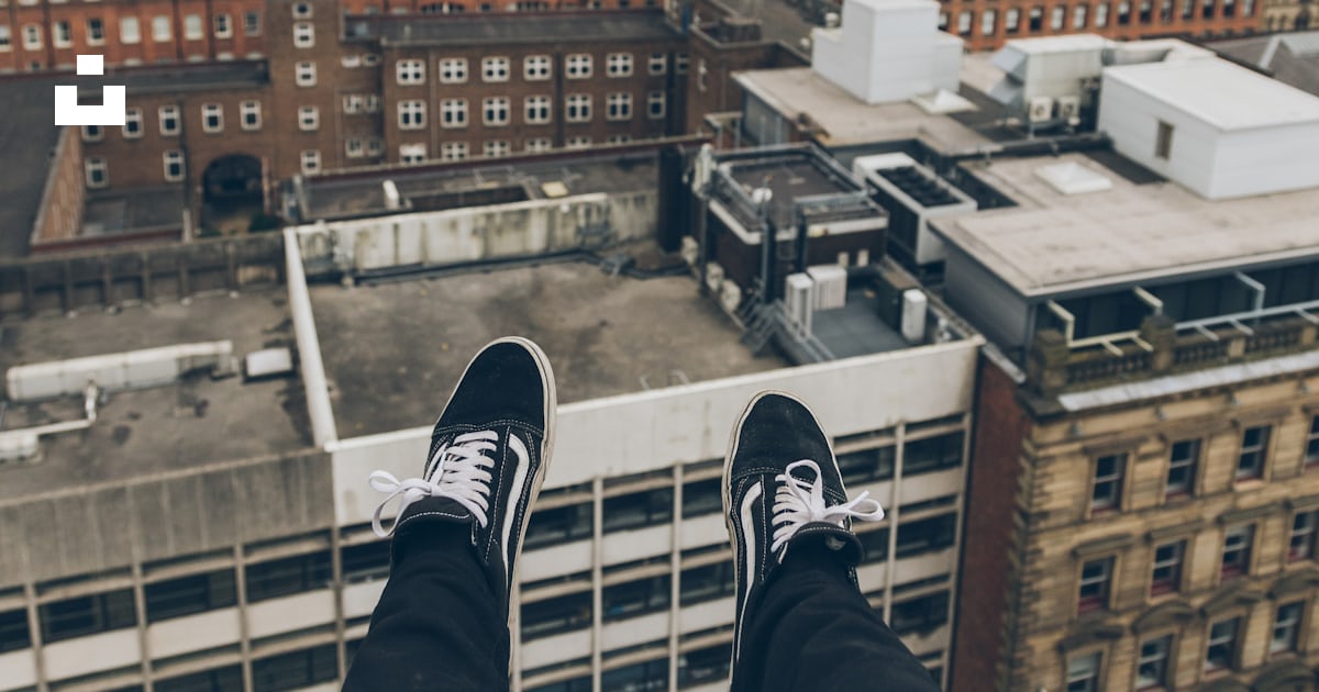 Person Sitting On Edge Of Building Rooftop Photo Free Manchester