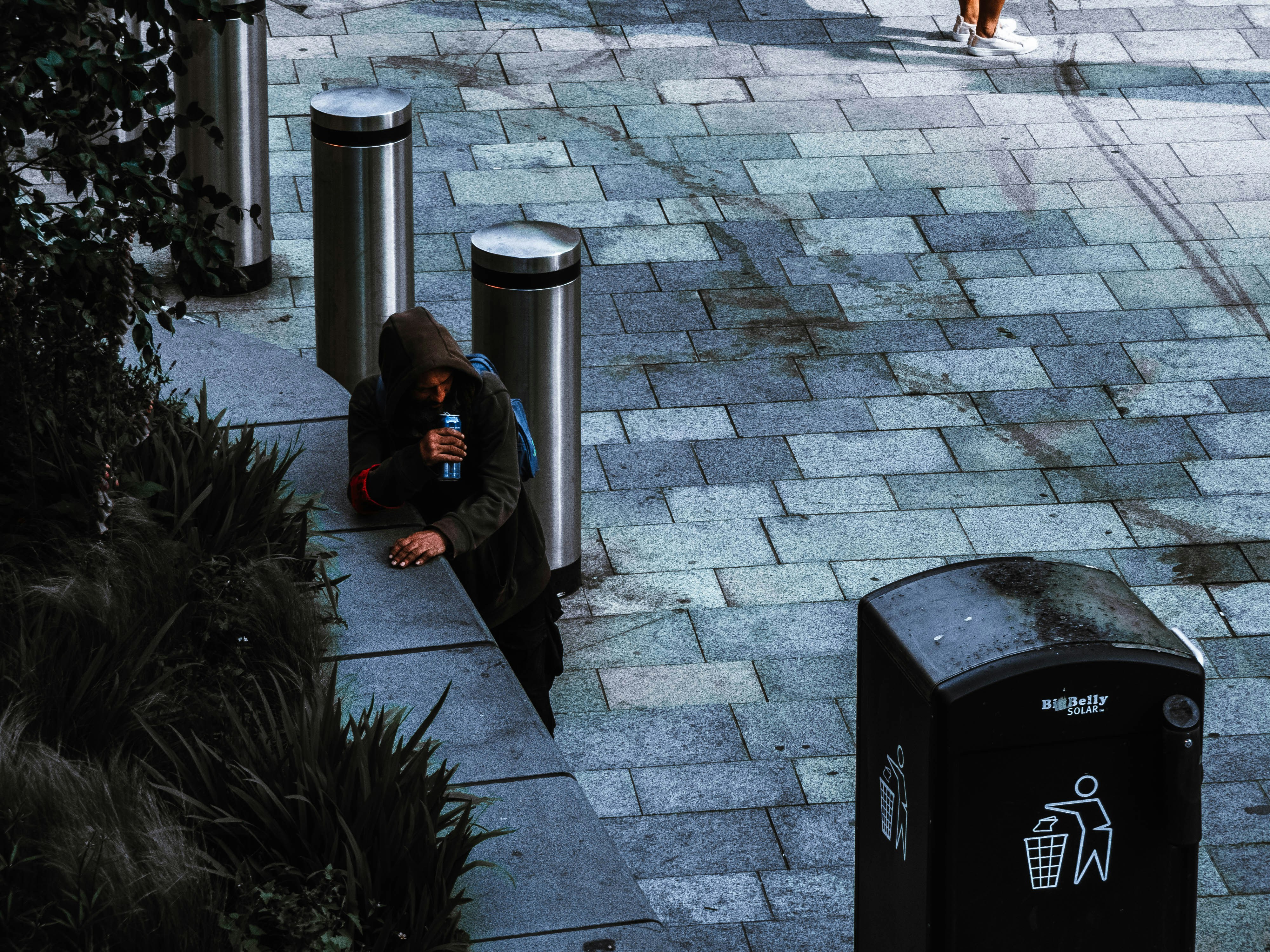man standing near black trash bin