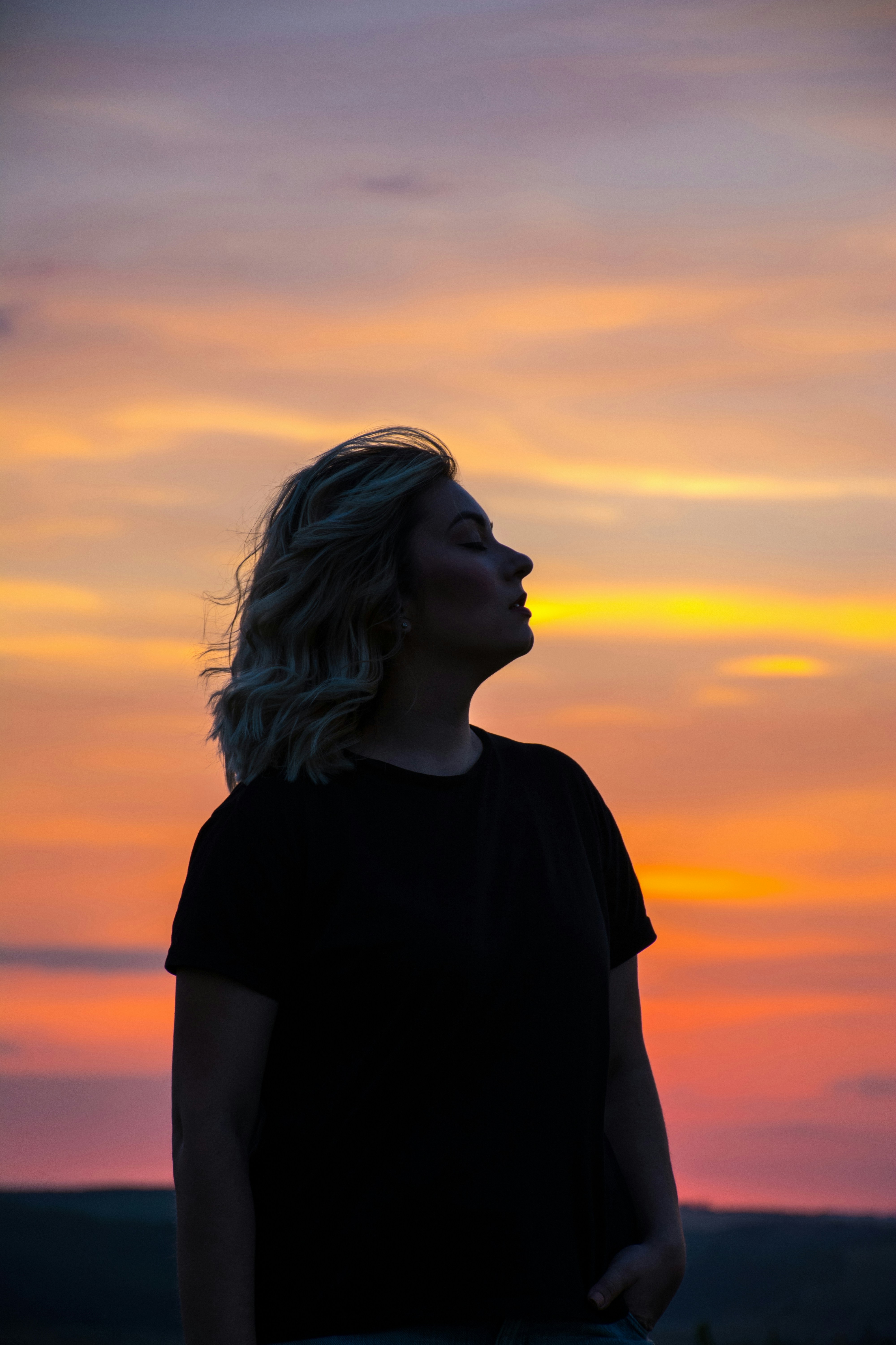 Silhouette at Dusk: A Quiet Portrait Beneath a Fiery Horizon