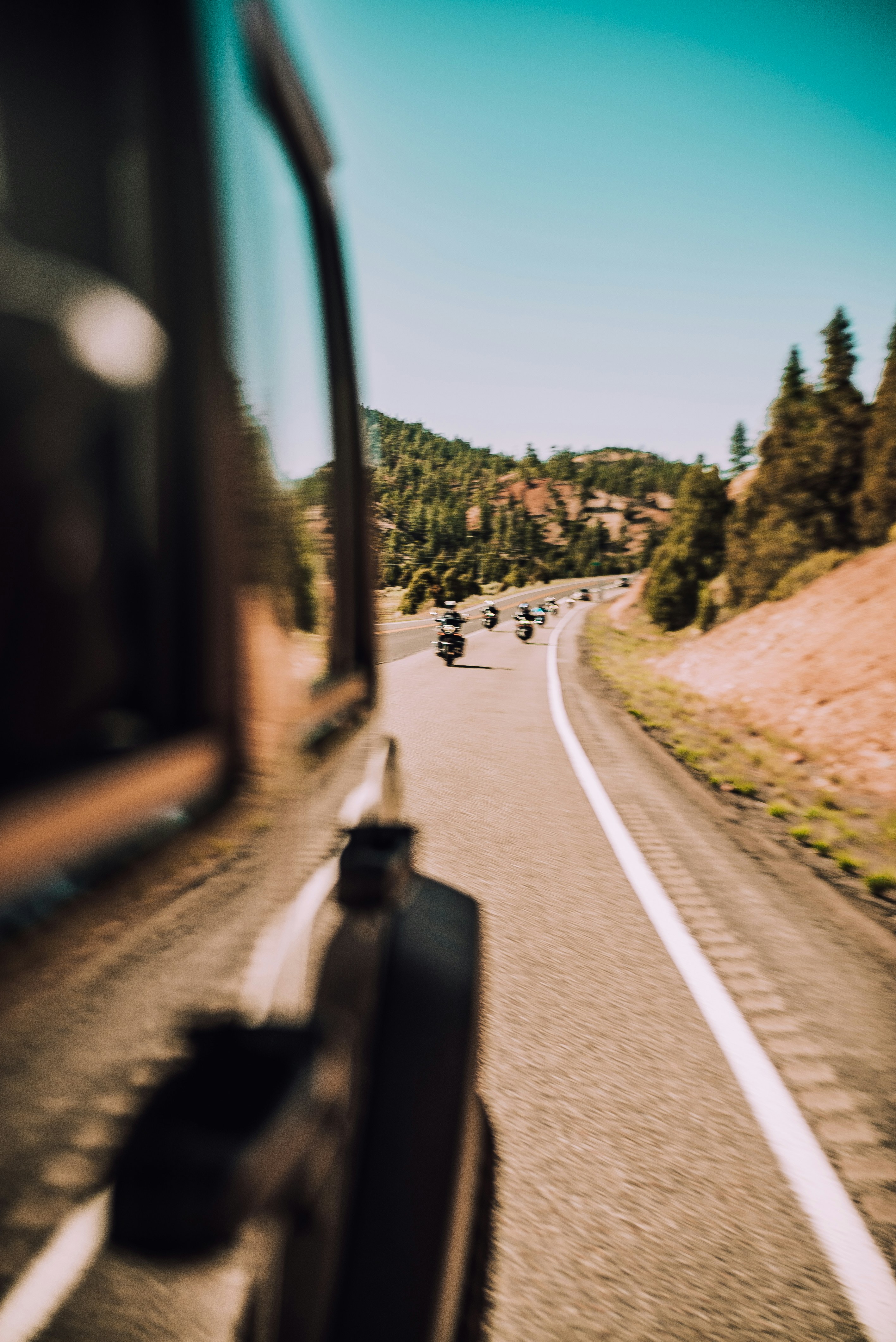 Rear-View Rally: Blurred Bikers on a Winding Mountain Highway
