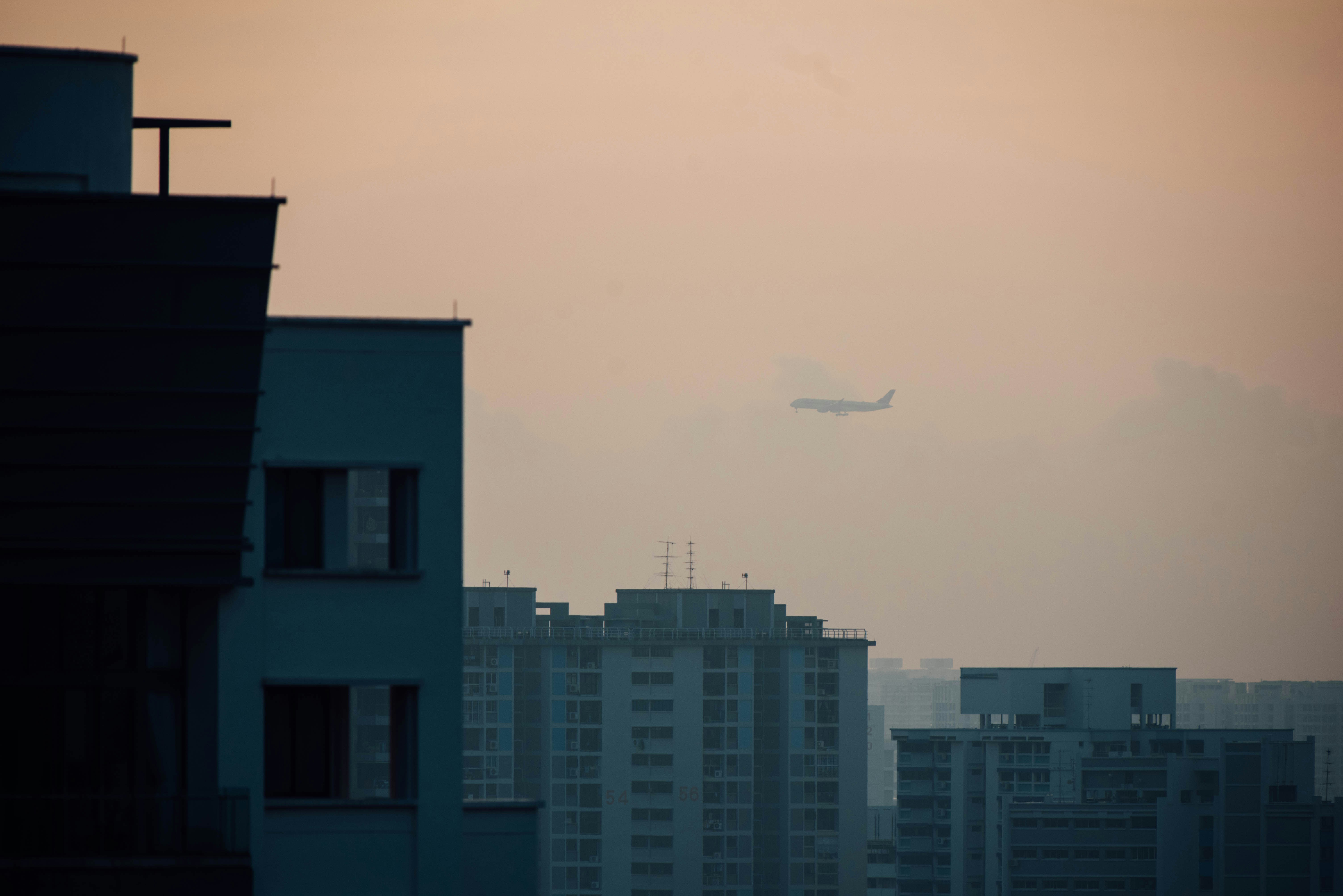 Plane over building during daytime photo – Free Brown Image on Unsplash