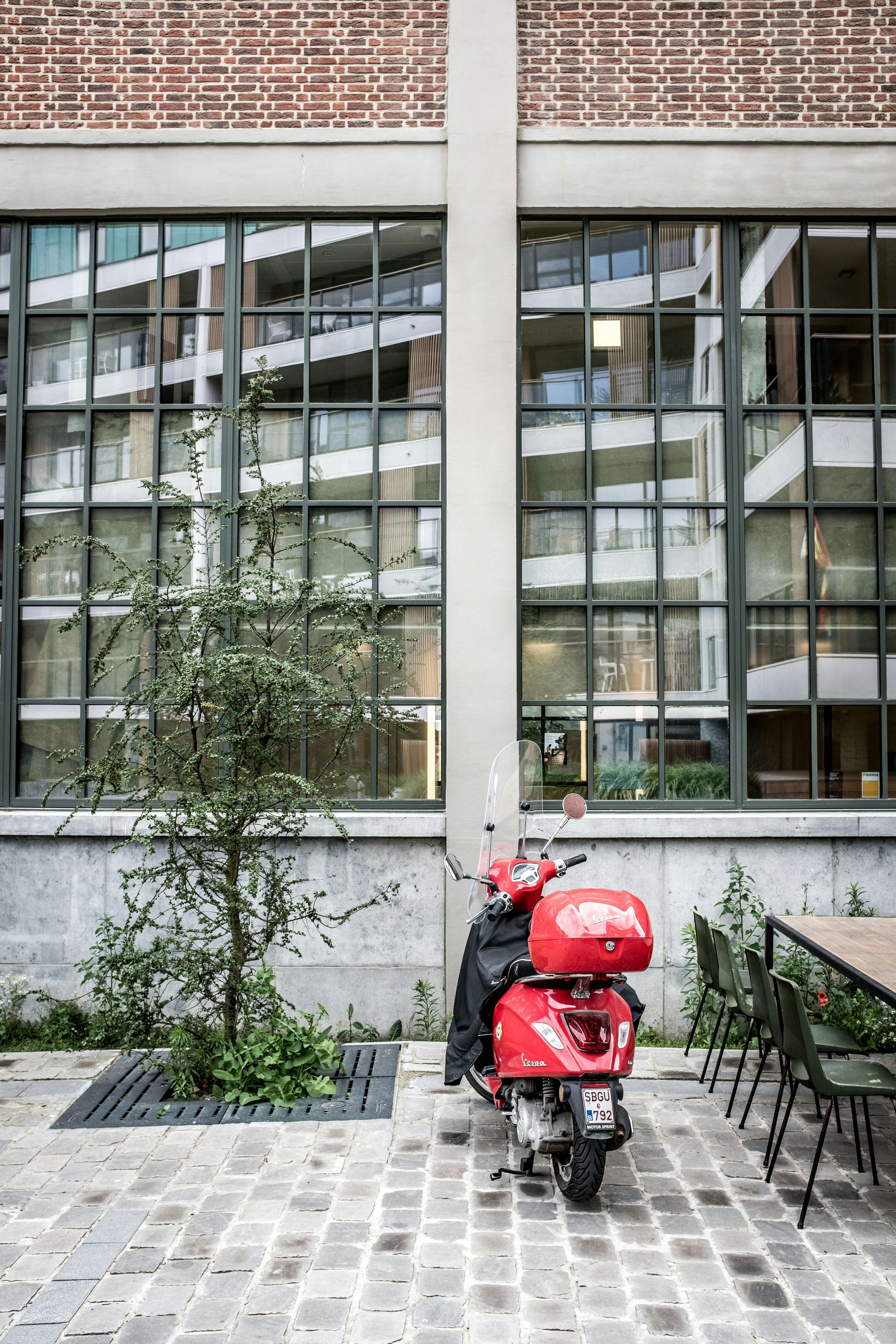 Red Vespa by a Glass-Fronted Courtyard