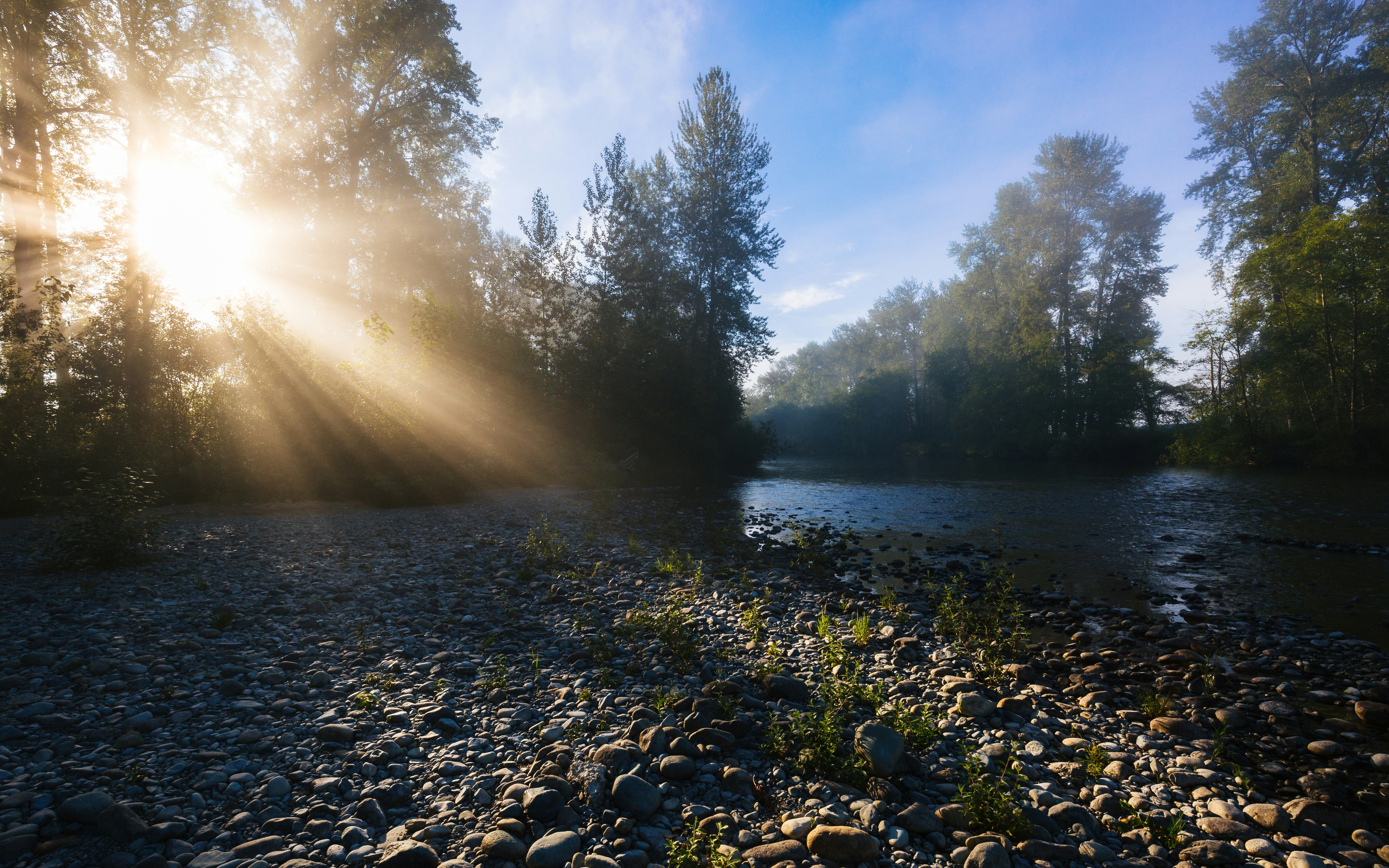 Dawn Sunburst over a Pebble Riverside