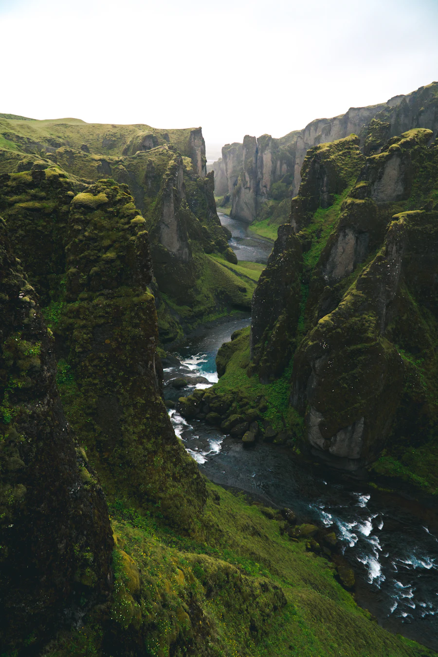 This is a remote canyon on the South Coast of Iceland, way too hard to pronounce or spell. We came here in a torrential downpour, which is honestly how most of the weather on iceland is and I took the best picture I could under the conditions given to me. | aerial view photography of body of water across green mountains