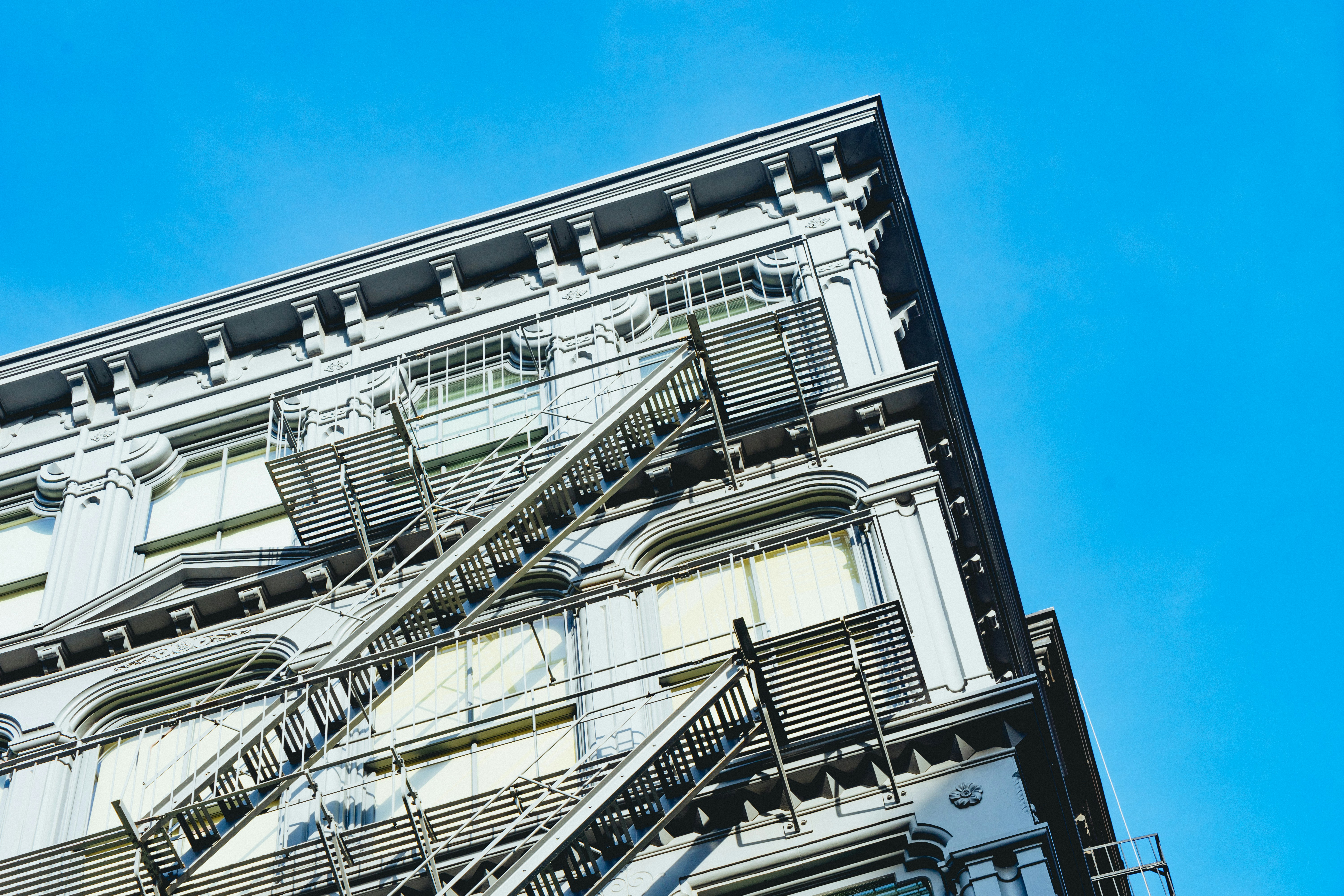 Historic building facade with intricate fire escape set against a bright blue sky.