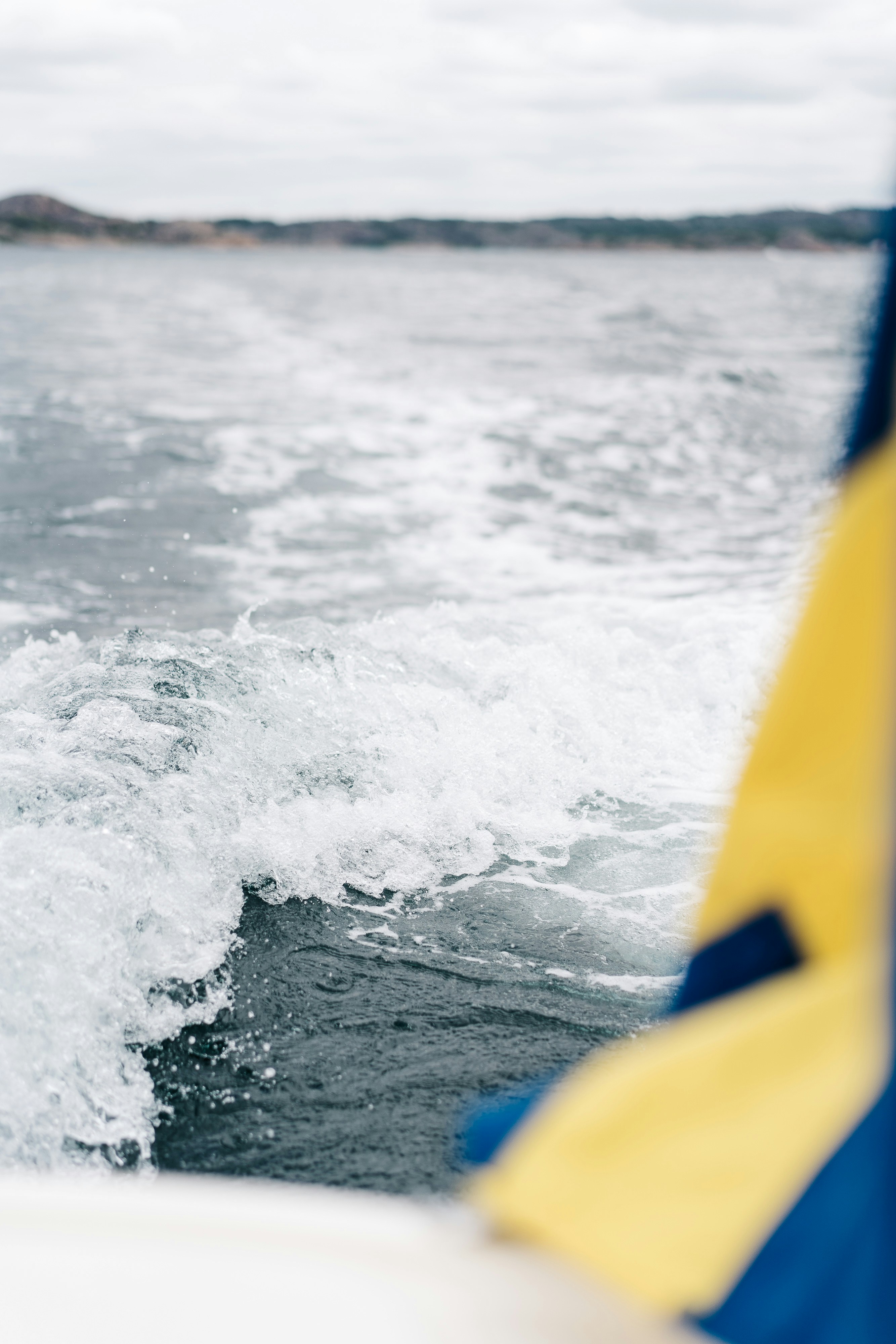 Wake Crest: Yellow-Blue Accent Skimming the Sea