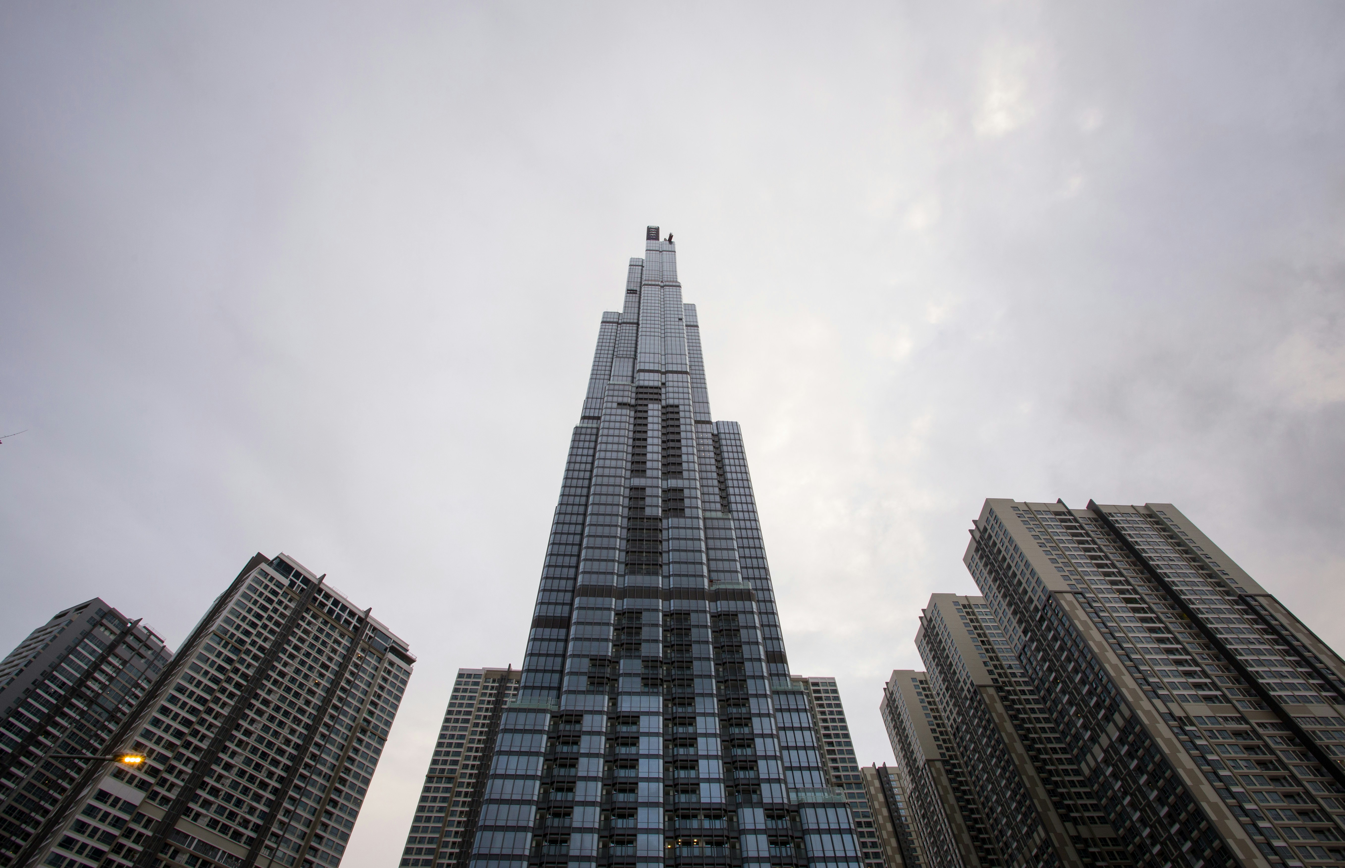 Willis Tower reaching towards an overcast sky, flanked by neighboring skyscrapers.
