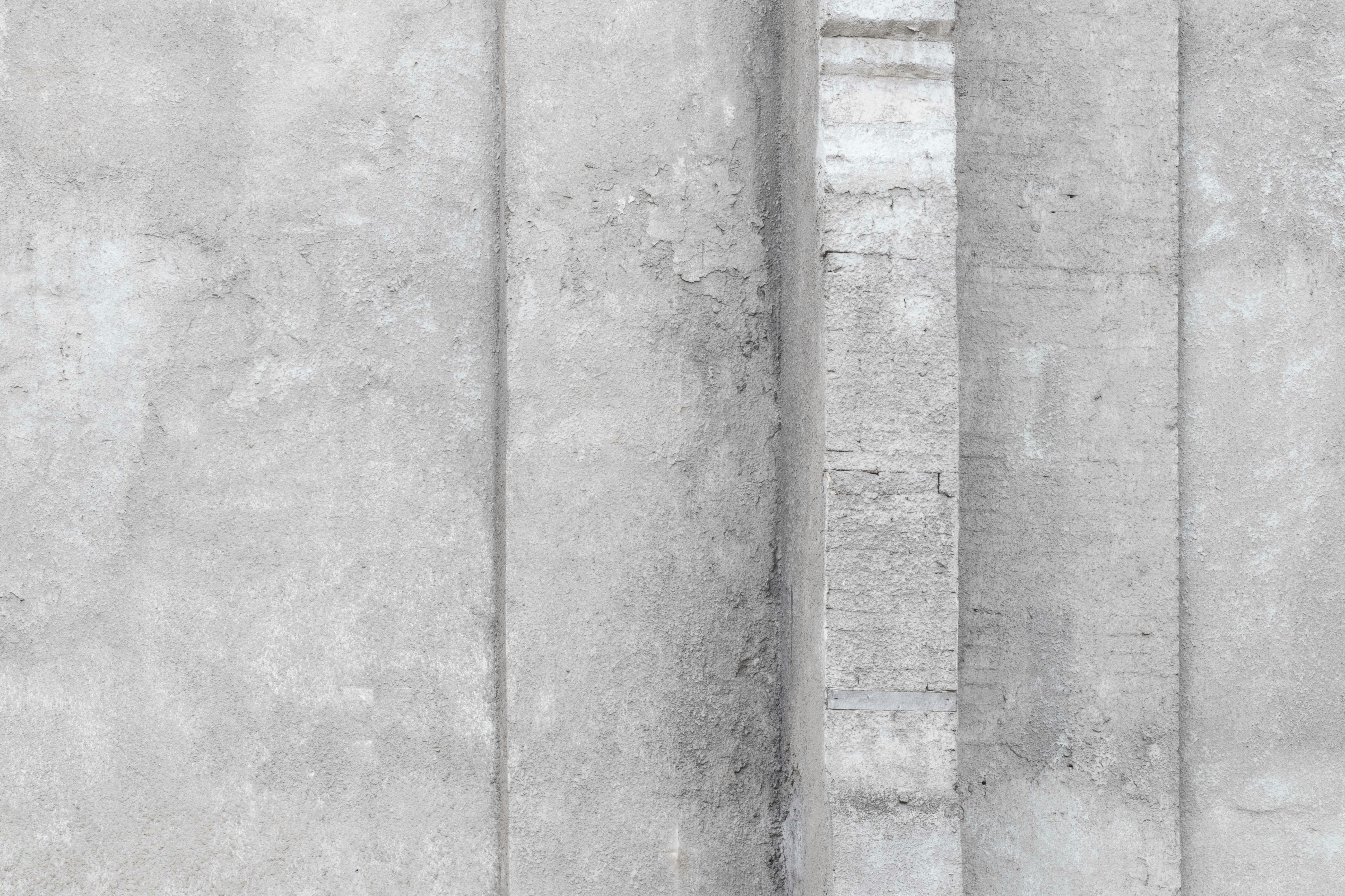 Close-up of a textured concrete wall with vertical lines and subtle shadow play.