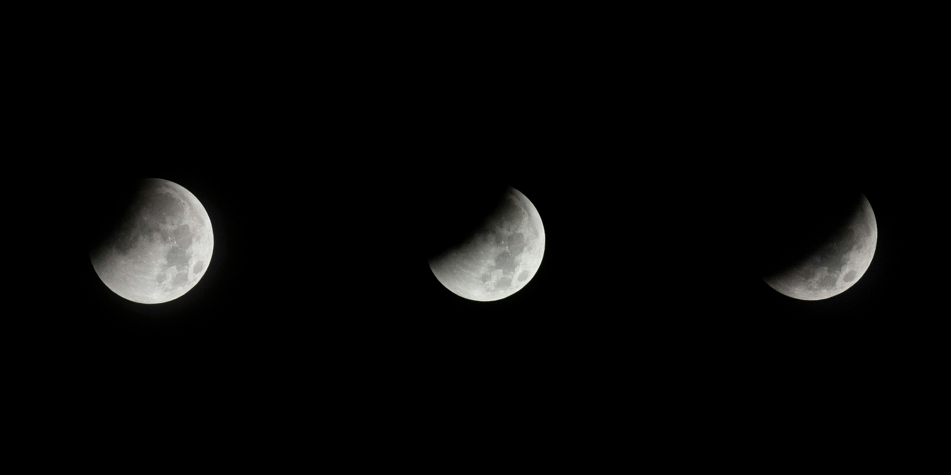 Three phases of the moon aligned against a dark night sky.