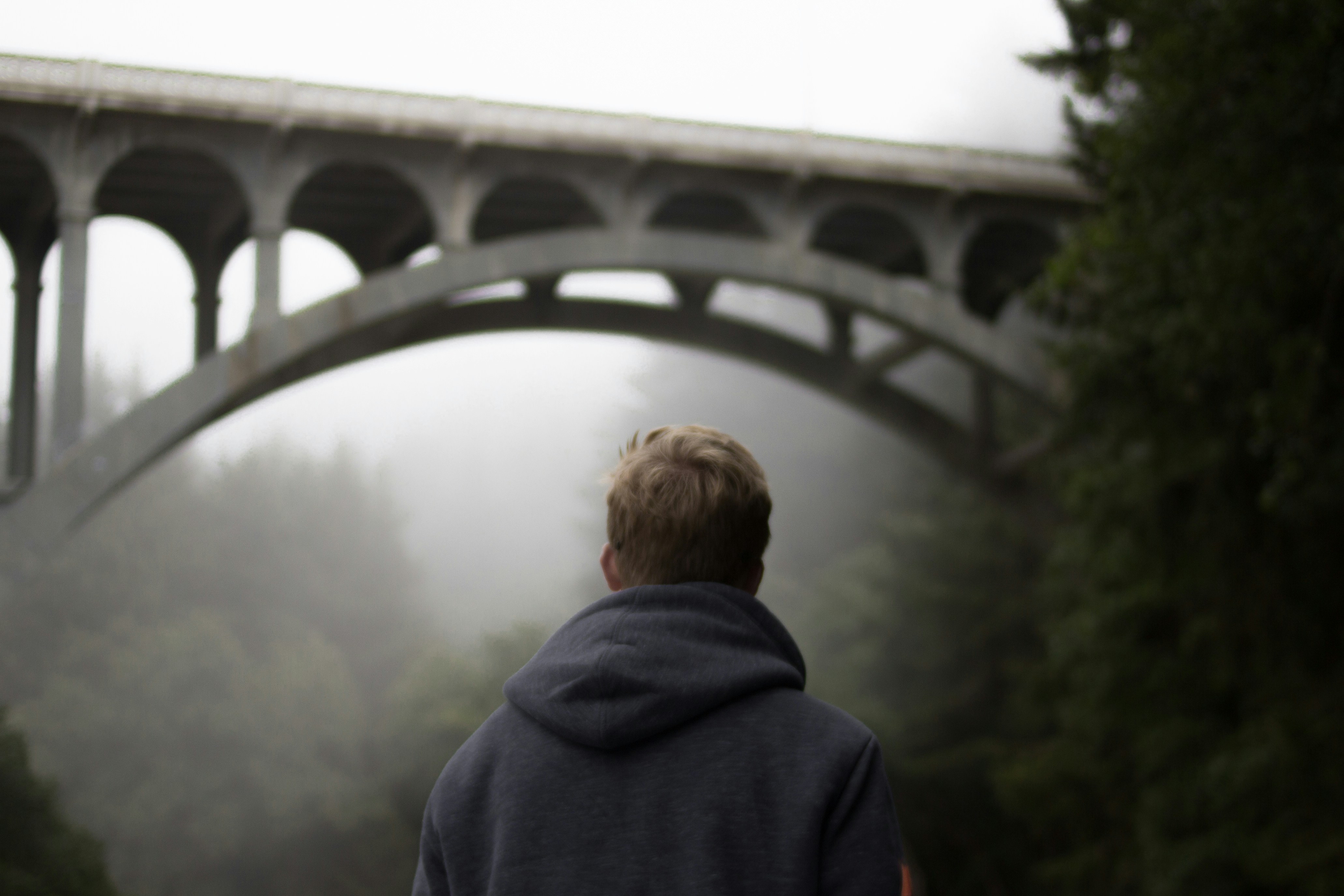 Hooded Stranger Beneath a Graced Bridge