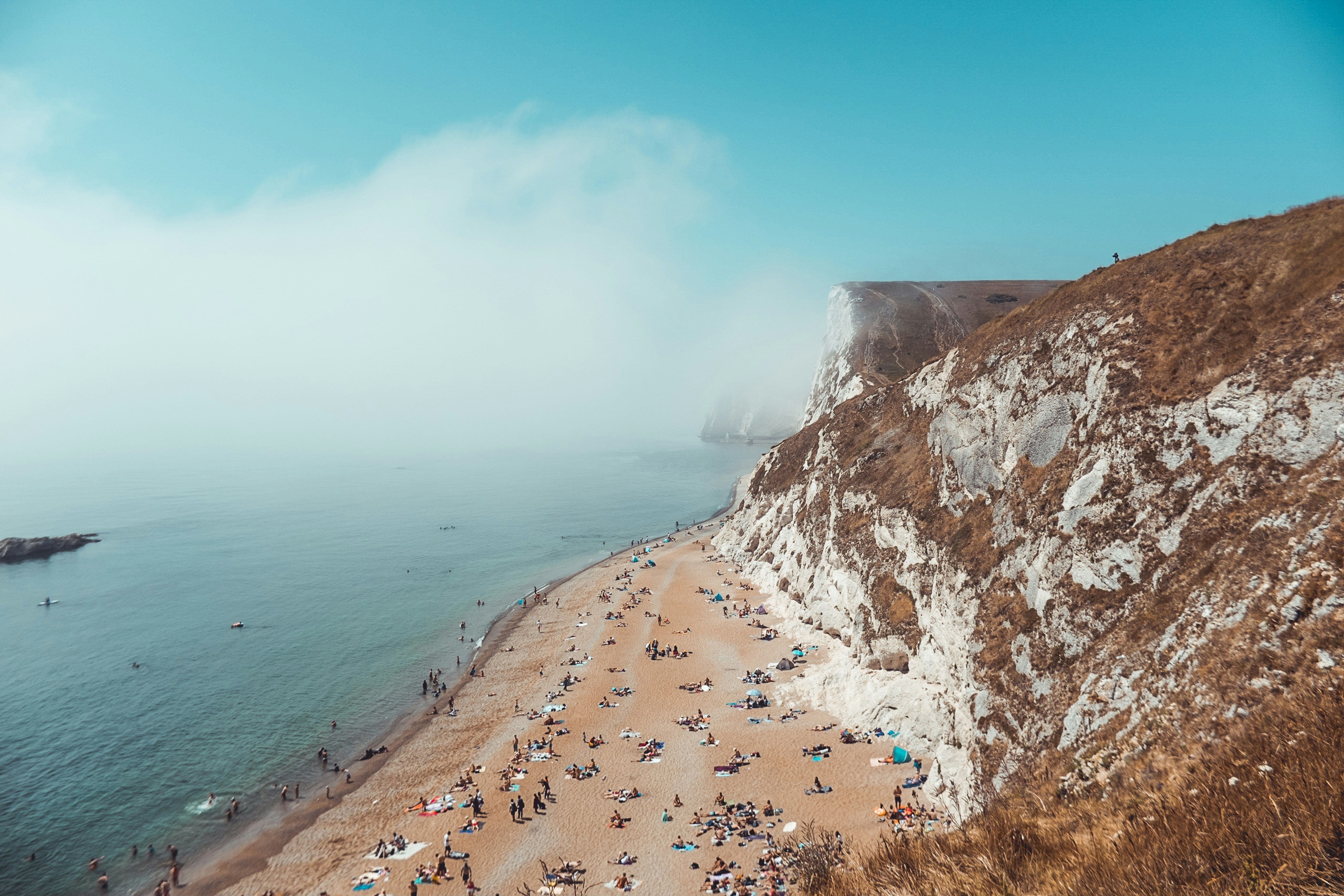 Chalk Cliff Overlook: Crowded Beach Beneath Coastal Mist