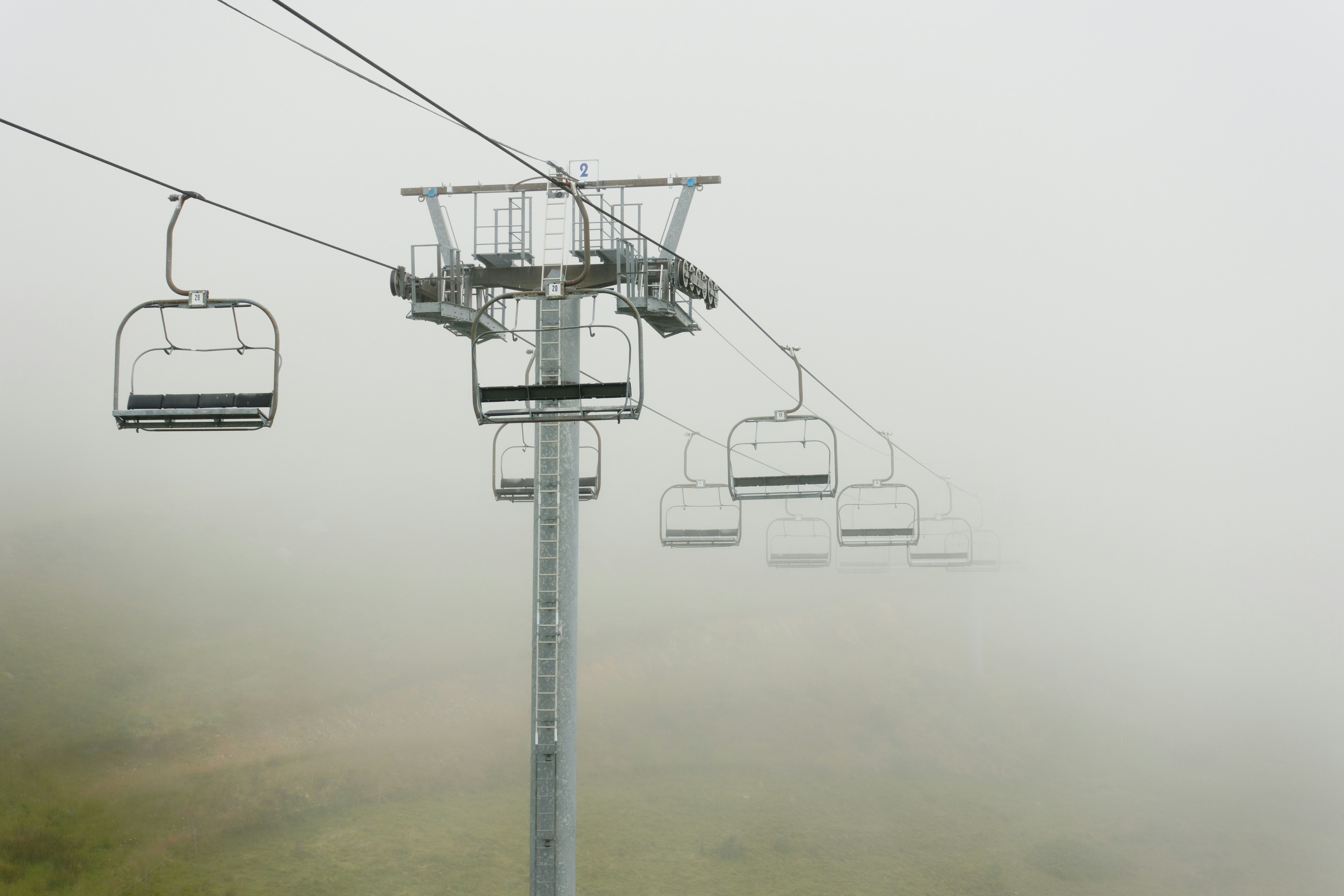 Mist-Wrapped Chairlift Over a Pale Valley