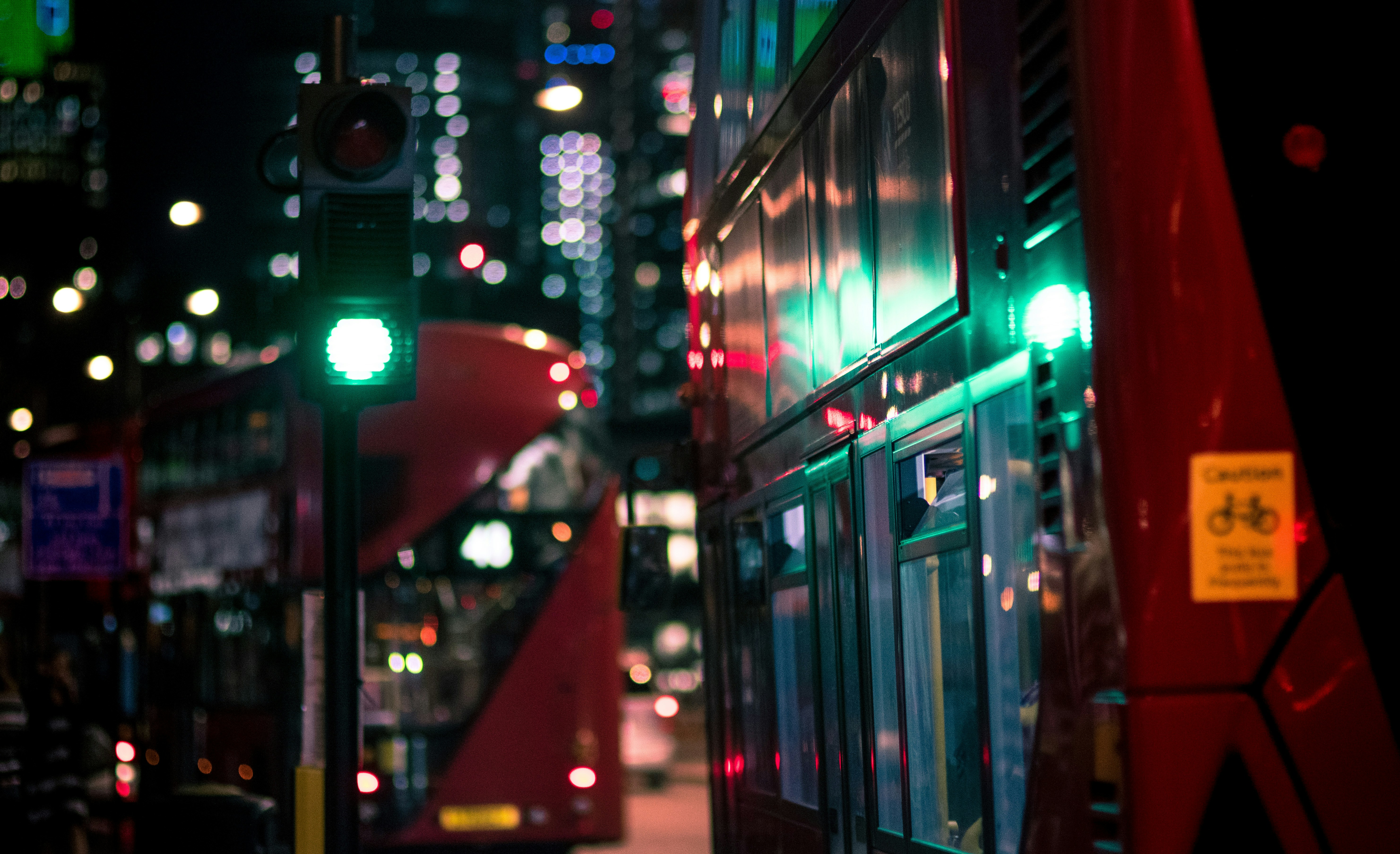 Neon Green Signal at a Night Platform with a Red Train
