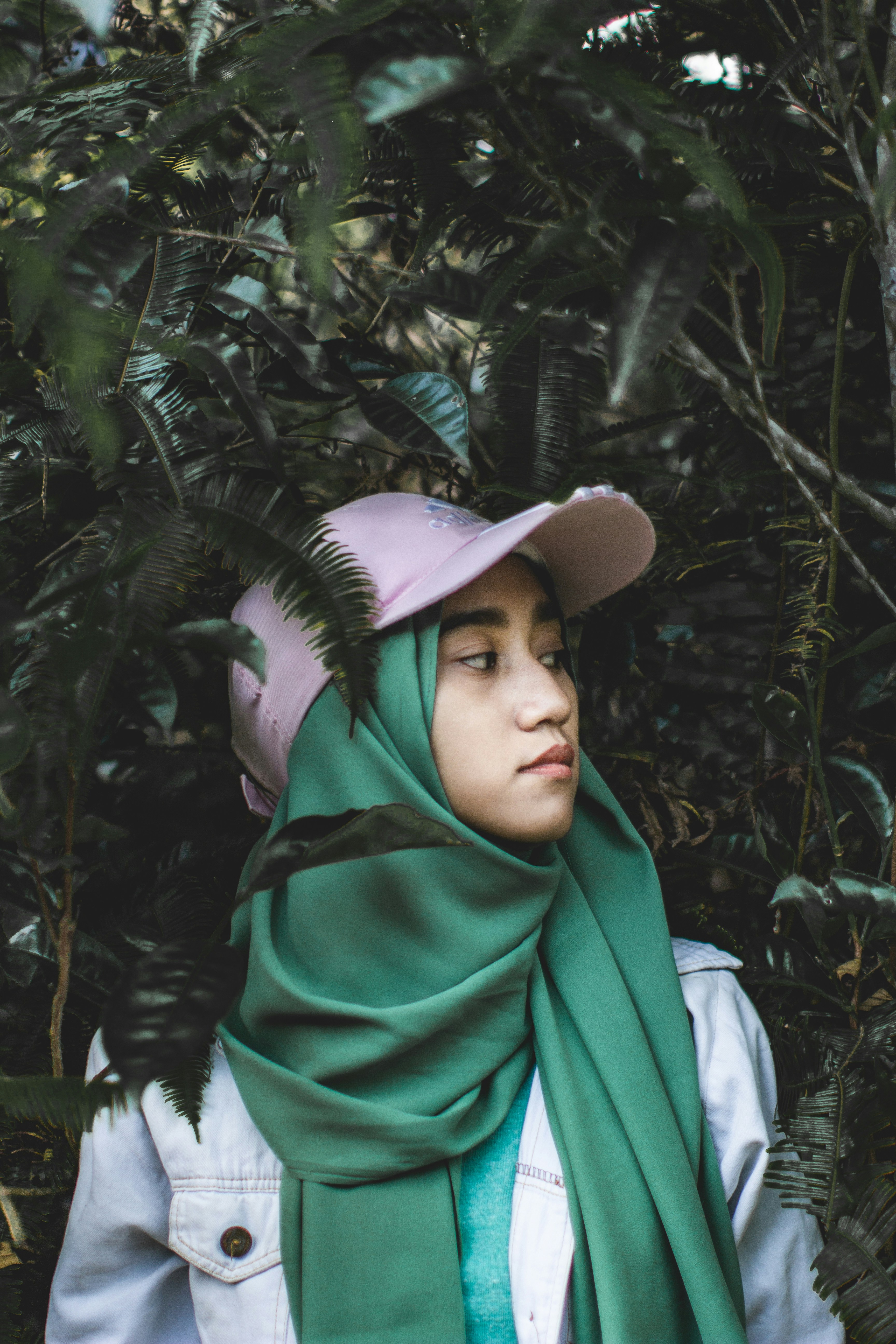Verdant Veil: A Portrait Framed by Ferns and Soft Light