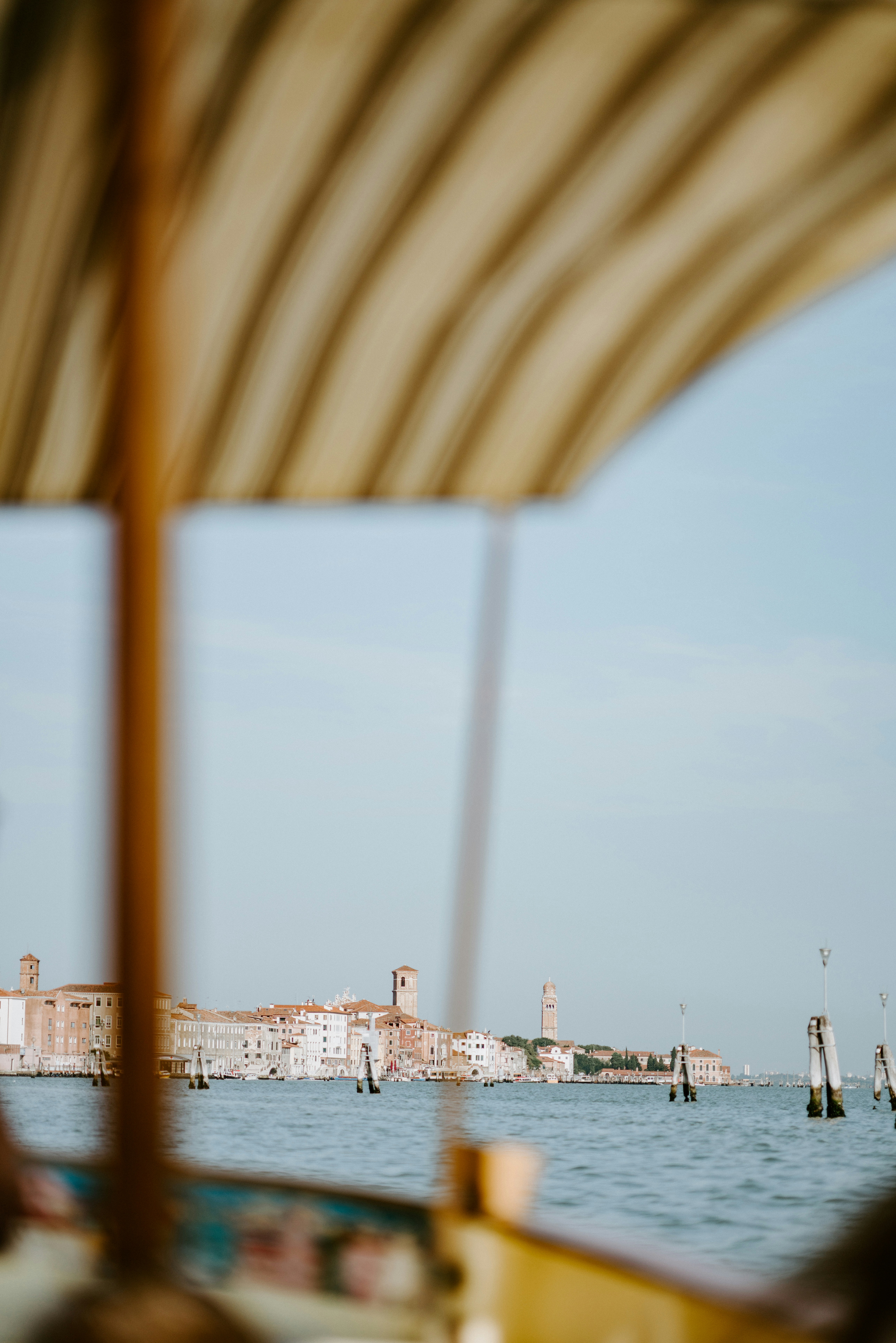 Canopy Framing Venice: A Quiet Wake Across Calm Waters