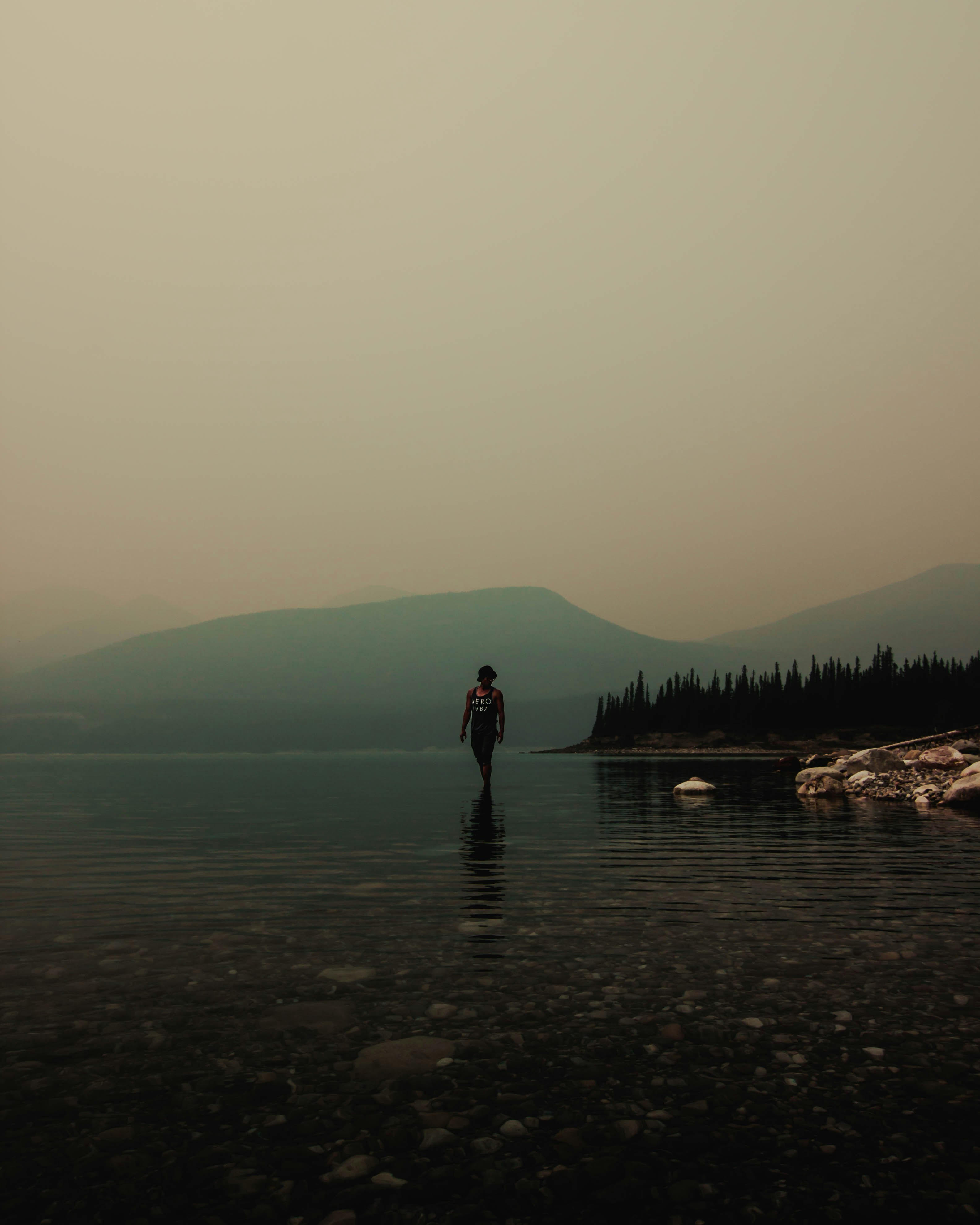 Man standing on body of water and view of mountains photo – Free Grey ...